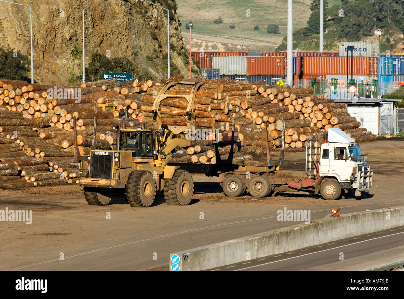 Timber being loaded onto a truck at a port Stock Photo - Alamy