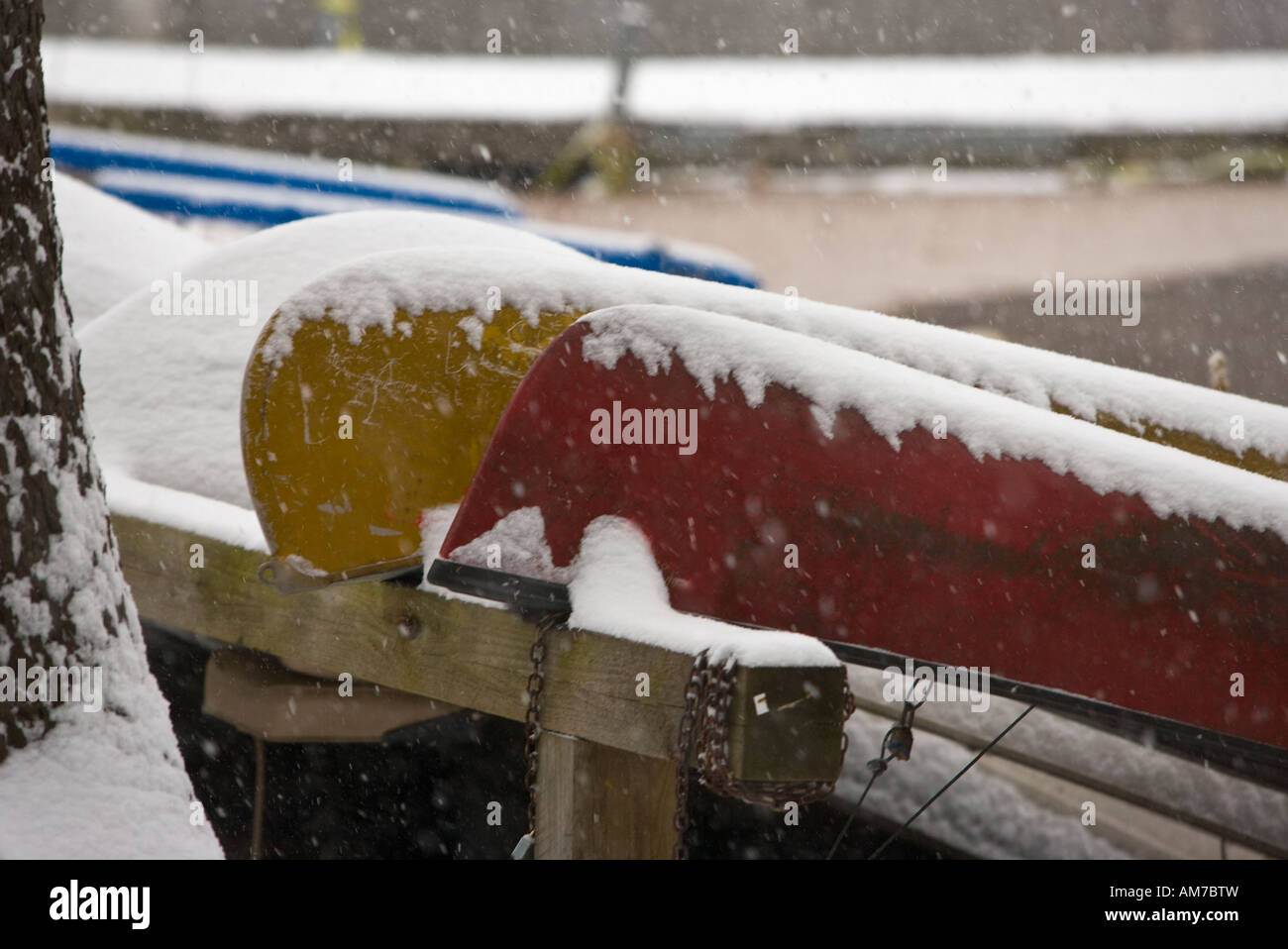 Snow covered canoes by the side of a lake Stock Photo - Alamy