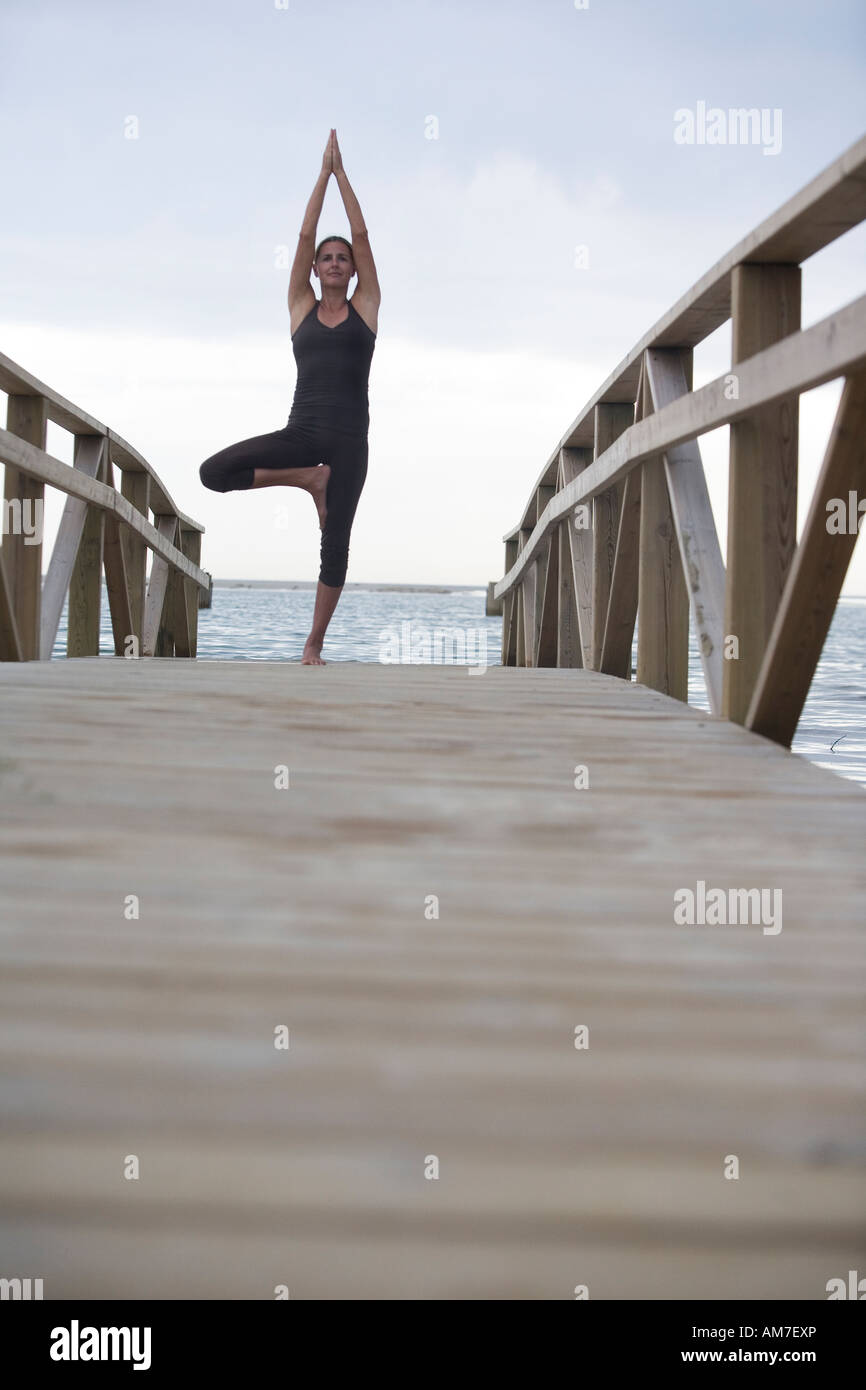 young woman doing yoga tree pose Stock Photo - Alamy