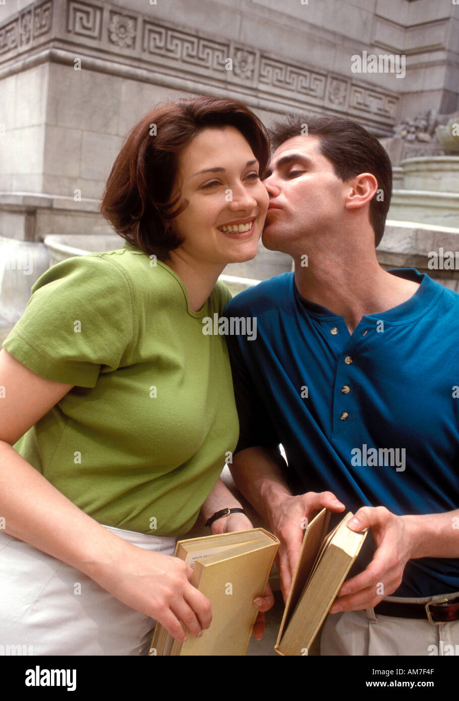 Couple with books kissing Stock Photo - Alamy