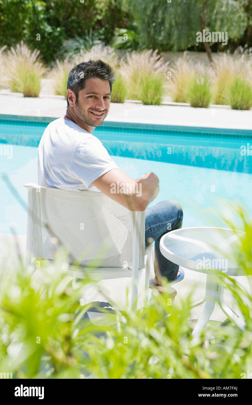 Man relaxing by swimming pool Stock Photo - Alamy