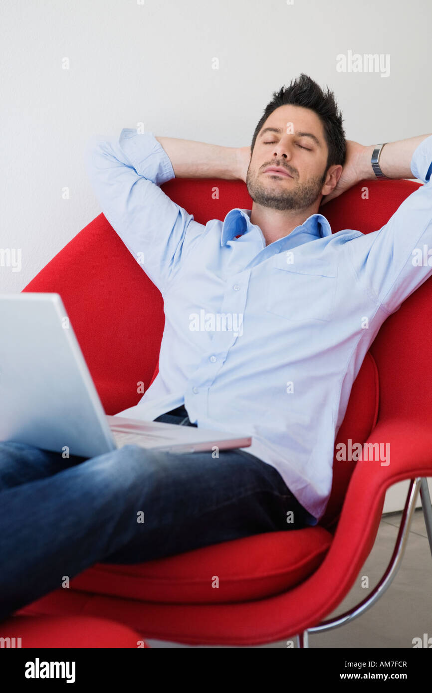 Man napping in armchair with laptop Stock Photo - Alamy