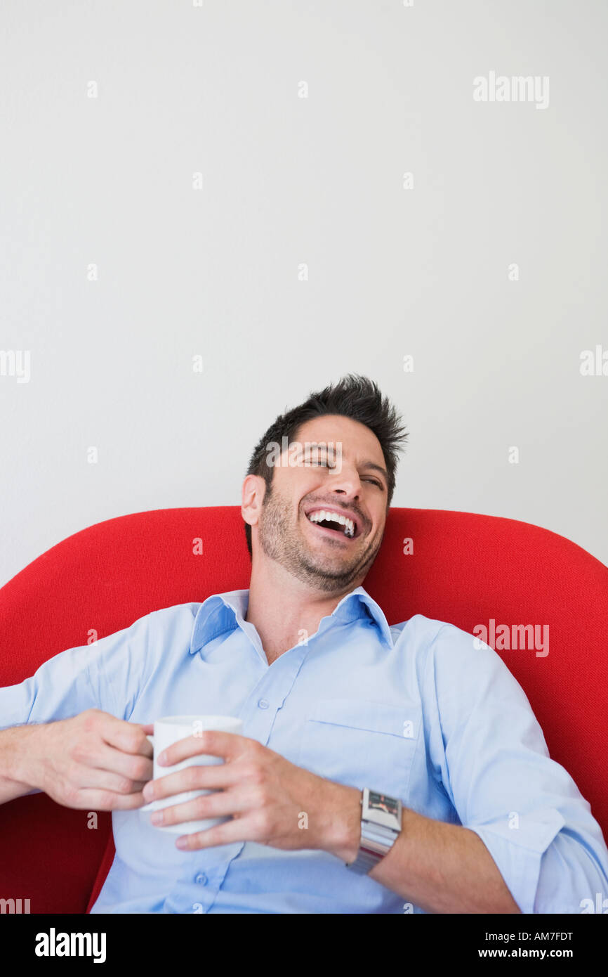 Man laughing while having a cup of coffee Stock Photo - Alamy