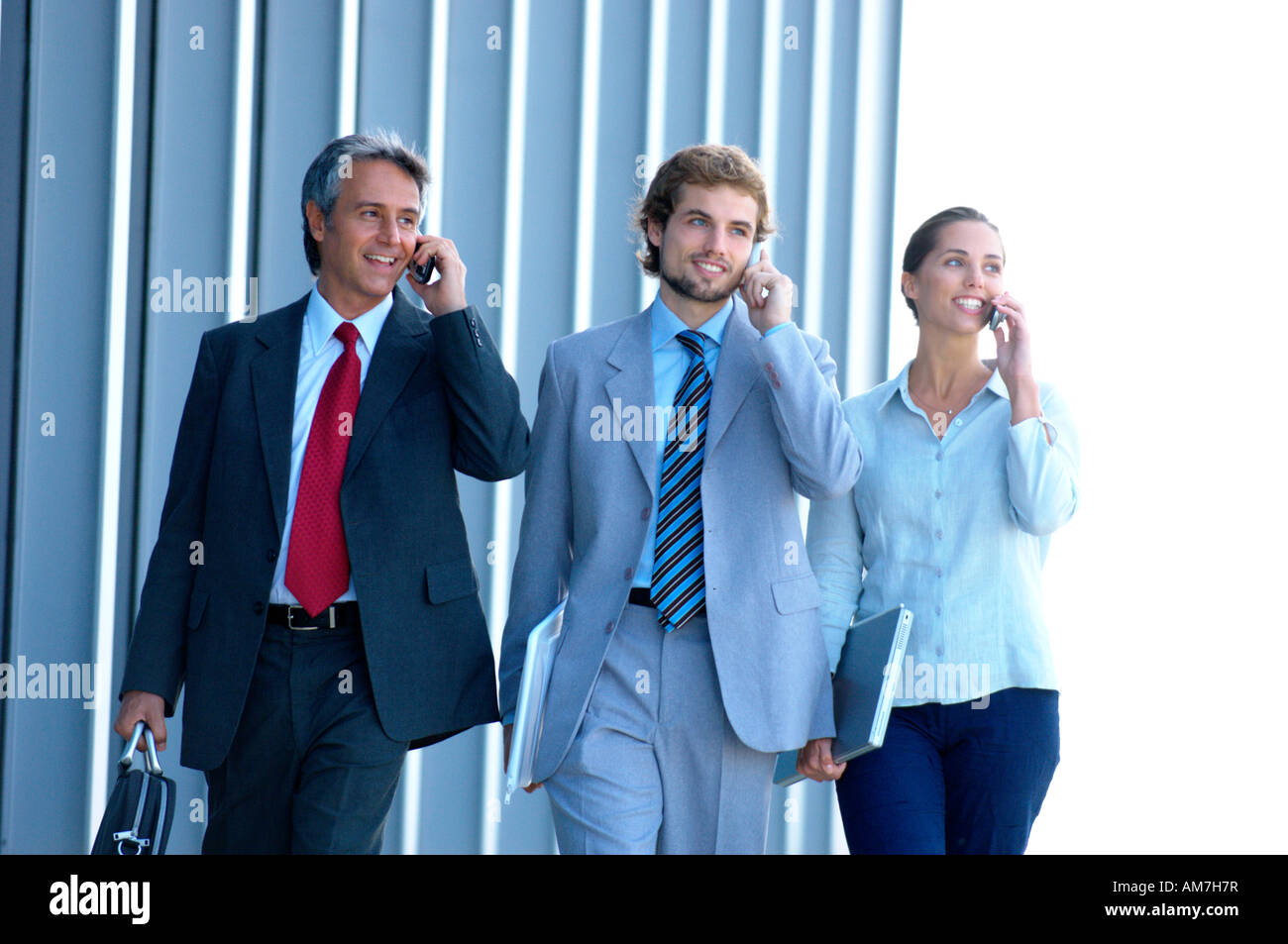 Business people using mobile phones, smiling Stock Photo - Alamy