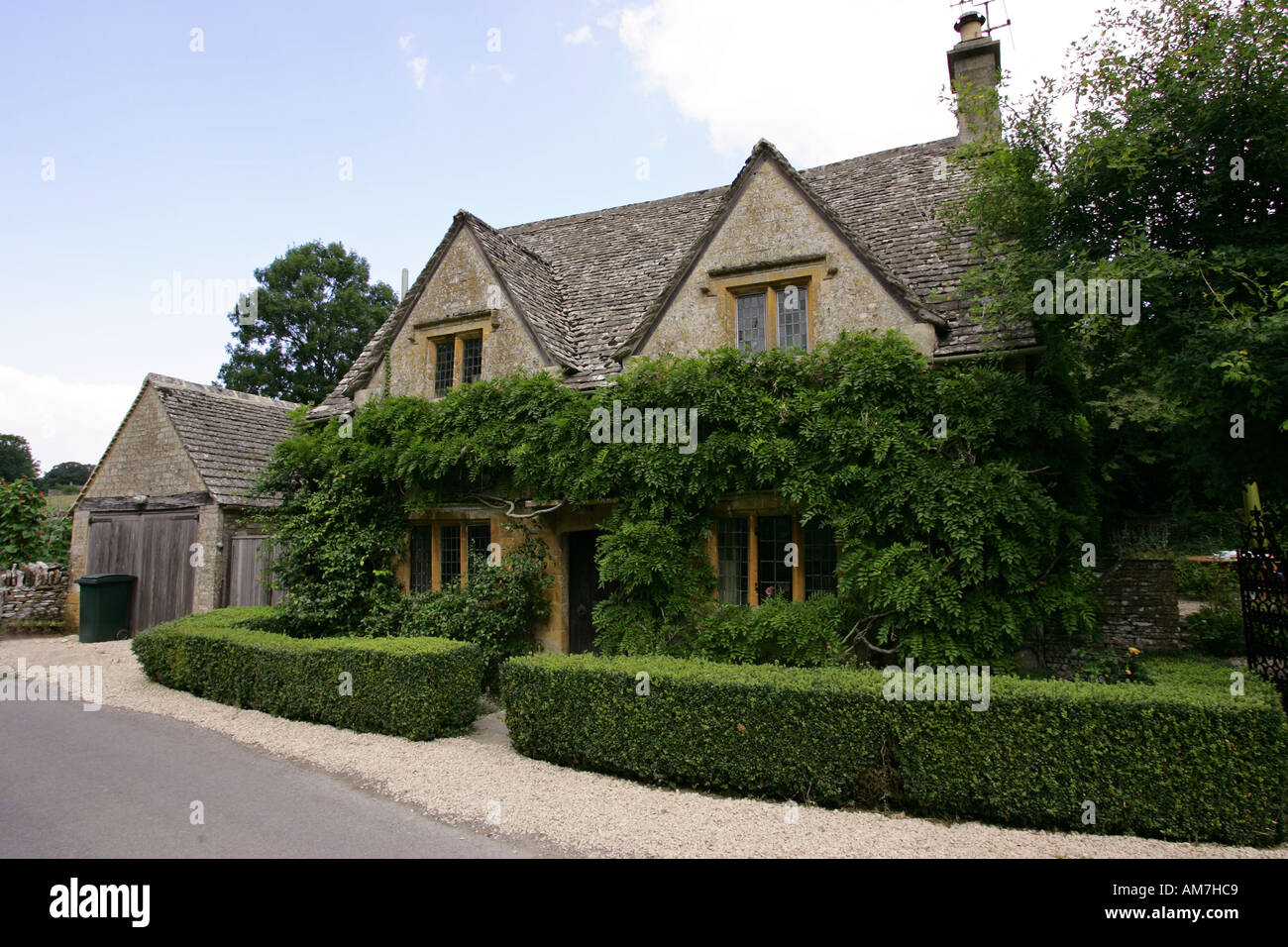 Typical green ivy covered Oolitic limestone Cotswold house cottage the ...