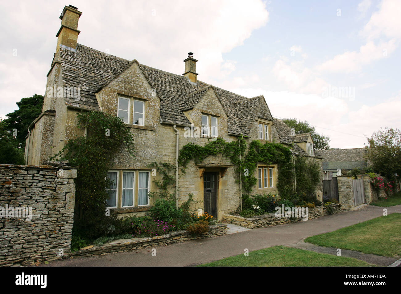 Typical green ivy covered Oolitic limestone Cotswold house cottage the ...