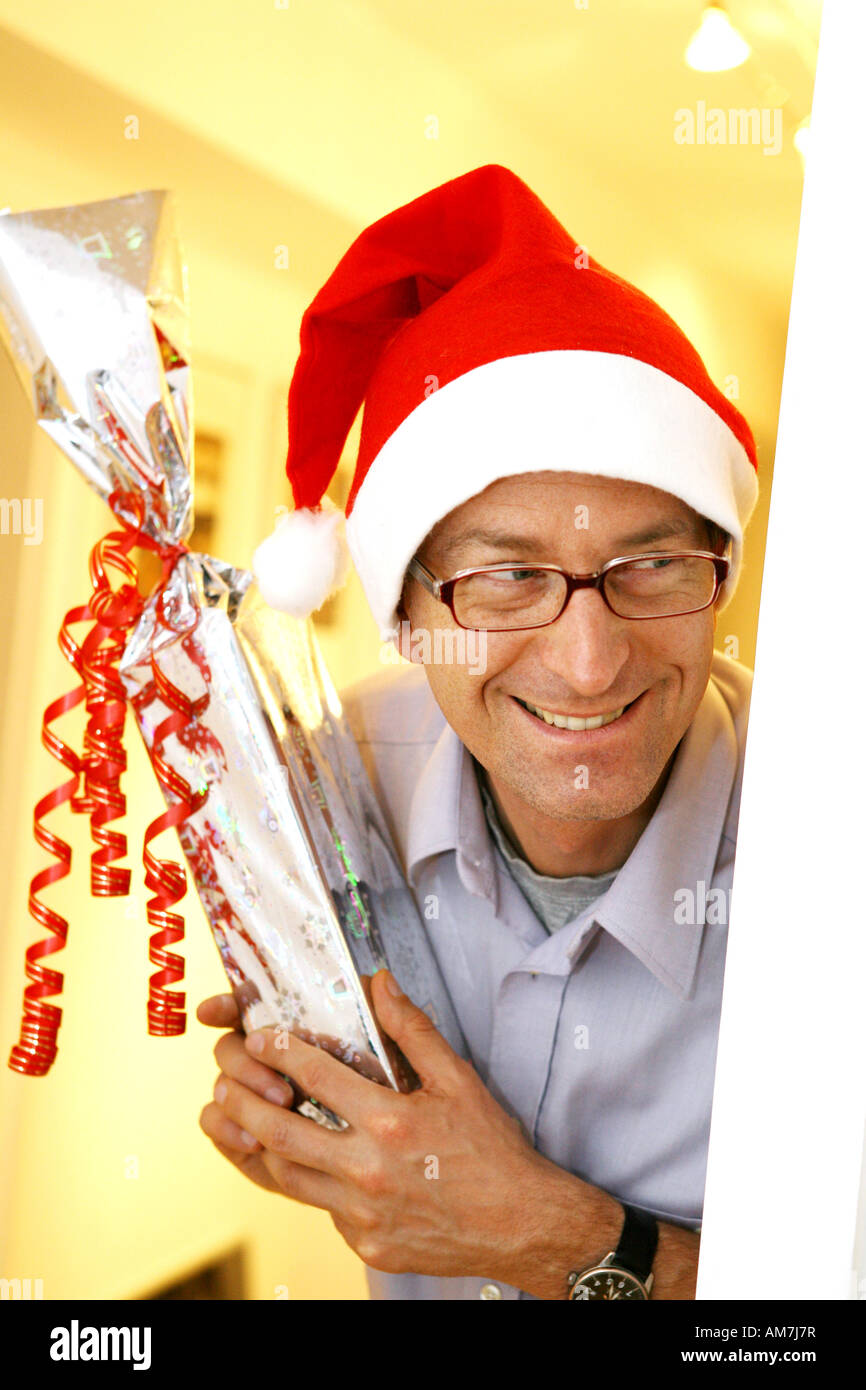 Man disguised as Santa Claus with a gift Stock Photo - Alamy