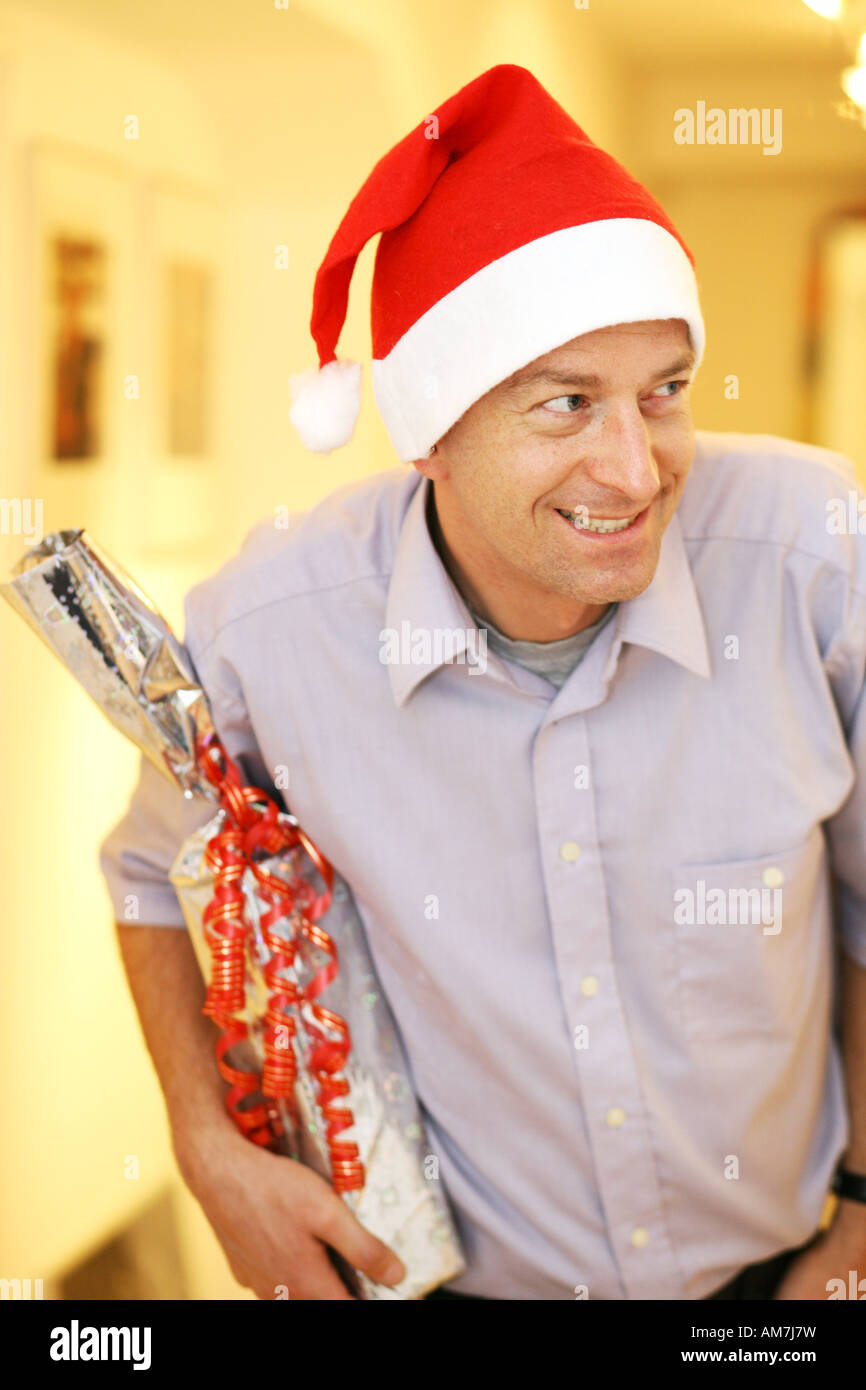 Man disguised as Santa Claus with a gift Stock Photo - Alamy