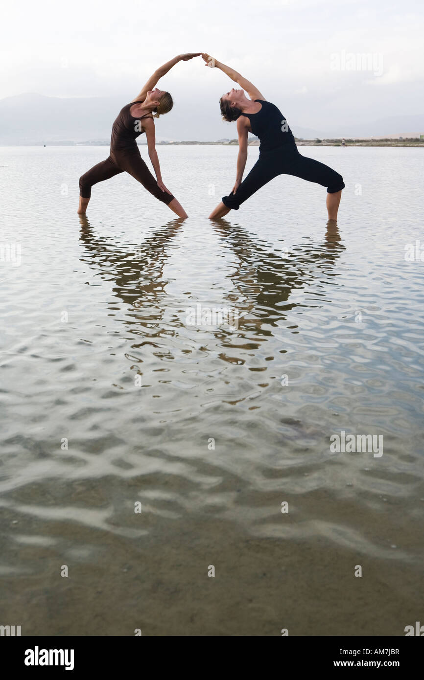 couple of women doing a yoga pose in water Stock Photo - Alamy
