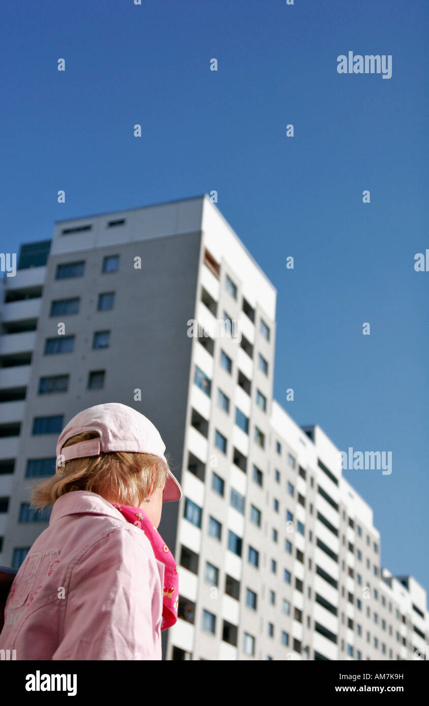 Little girl in front of a high-rise appartment complex Stock Photo - Alamy
