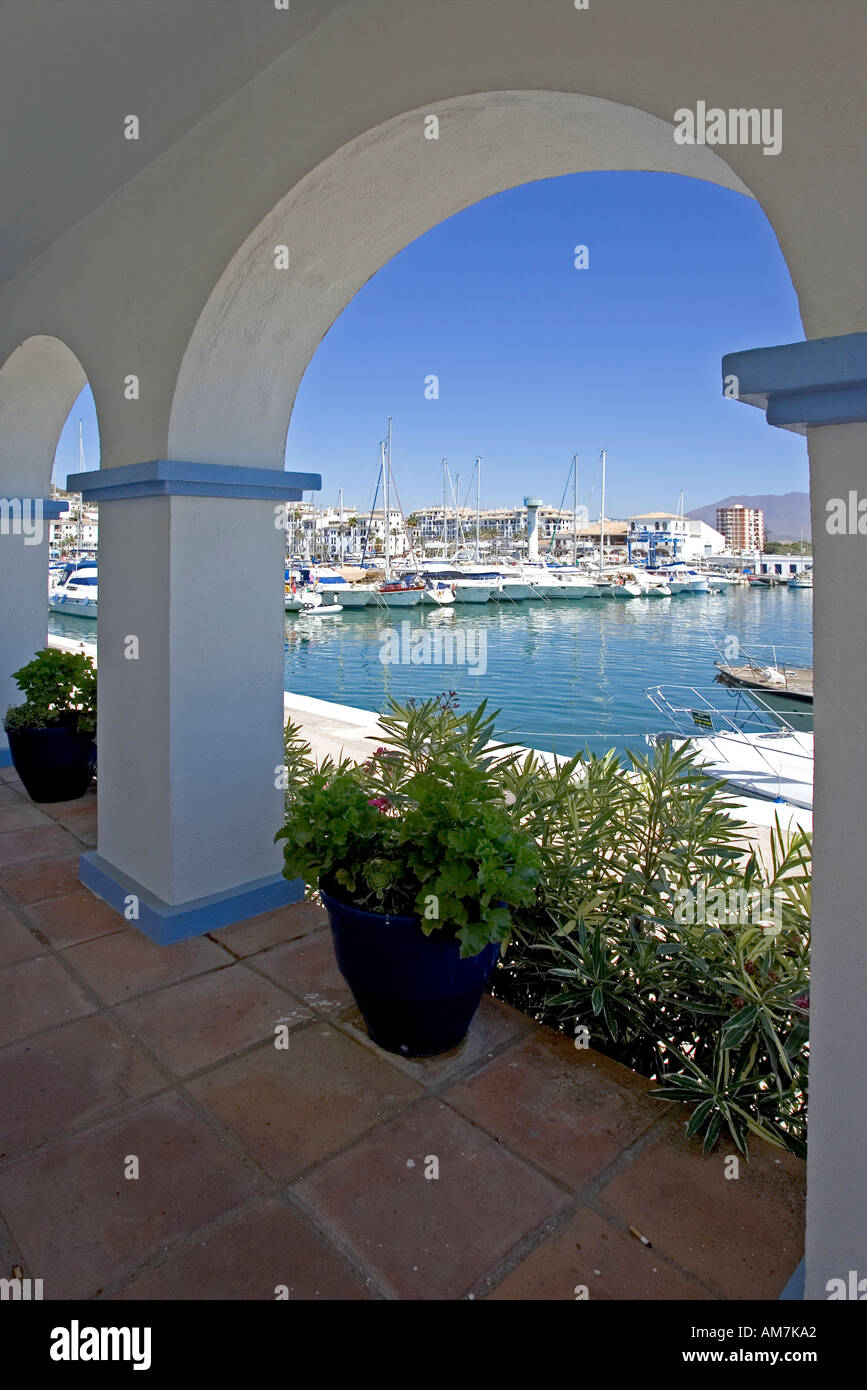 View through arch to Duquesa port and mountains Stock Photo - Alamy