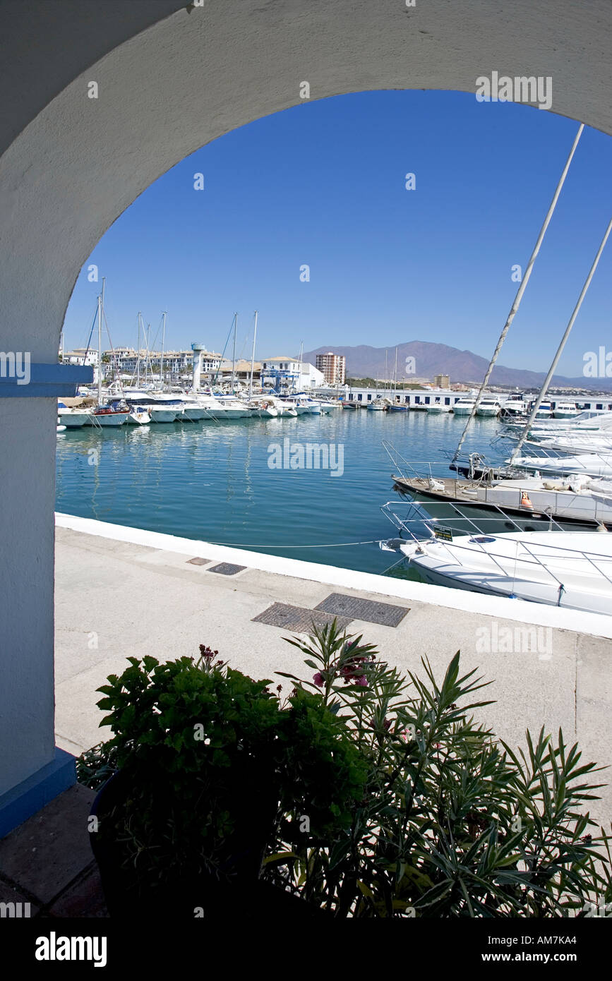 View through arch to Duquesa port and mountains Stock Photo - Alamy