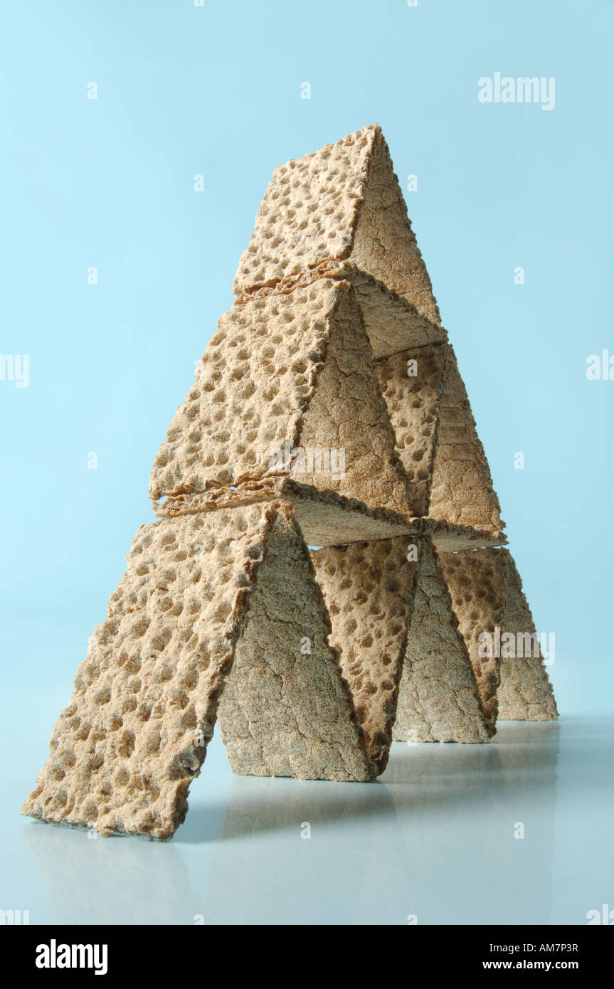 Pyramid of crispbreads stacked like a house of cards against a light ...