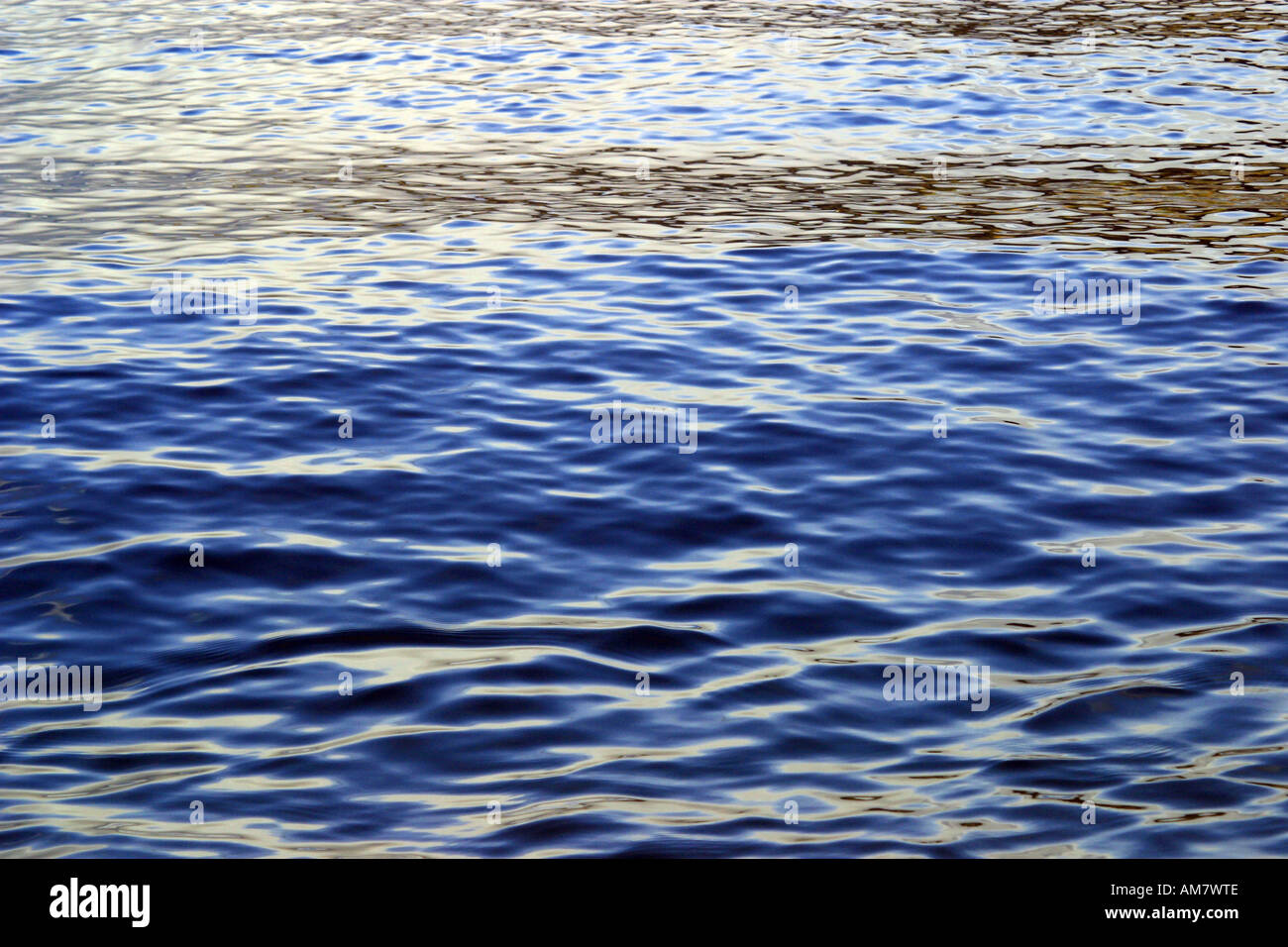 Sun reflecting off the ocean water surface with a wave approaching ...