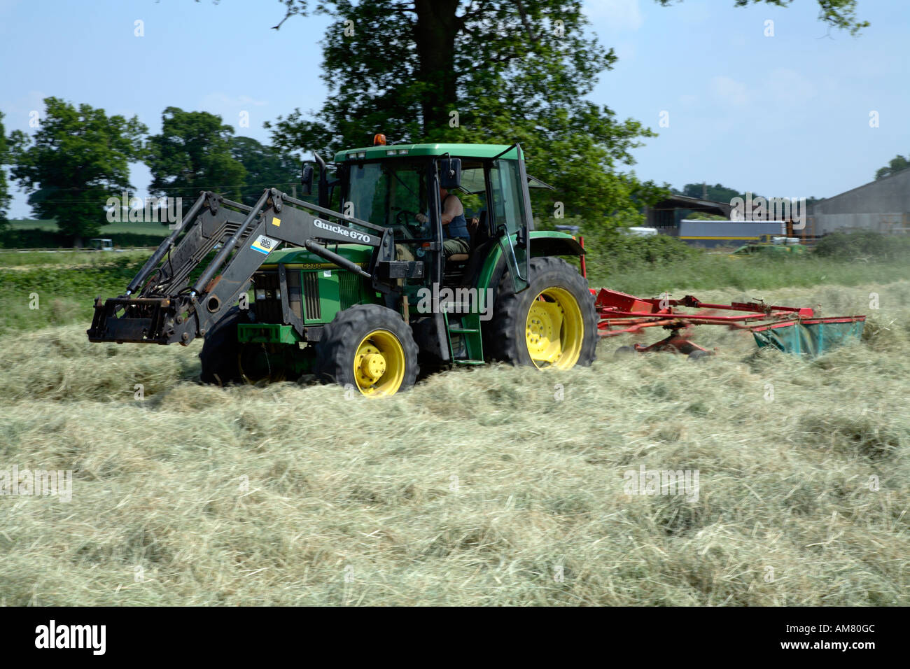 Farmer with tractor and rake rowing hay in summer meadow 3 Stock Photo ...