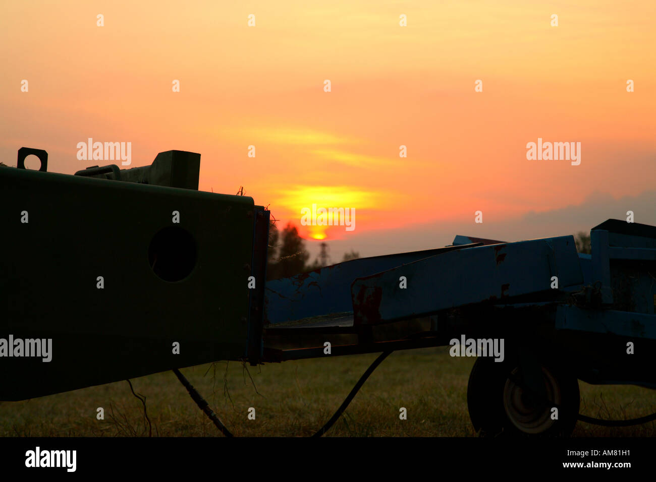Farm machinery in silhouette against summer haymaking sunset 1 Stock ...