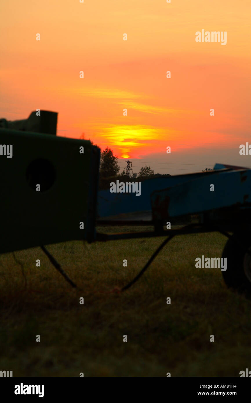 Farm machinery in silhouette against summer haymaking sunset 2 Stock ...