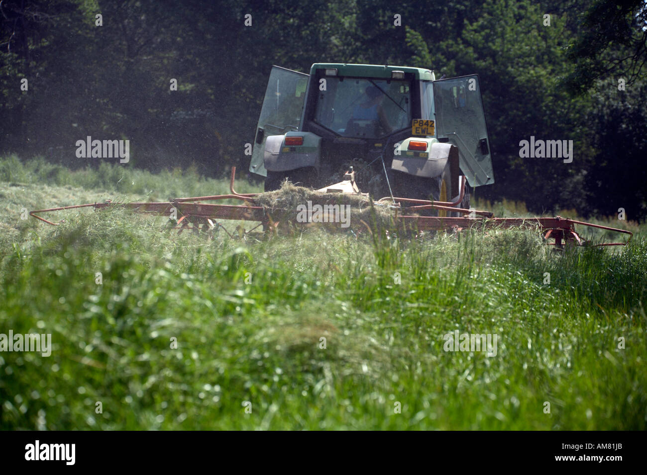 Female farm worker in tractor turning hay in summer 4 Stock Photo - Alamy