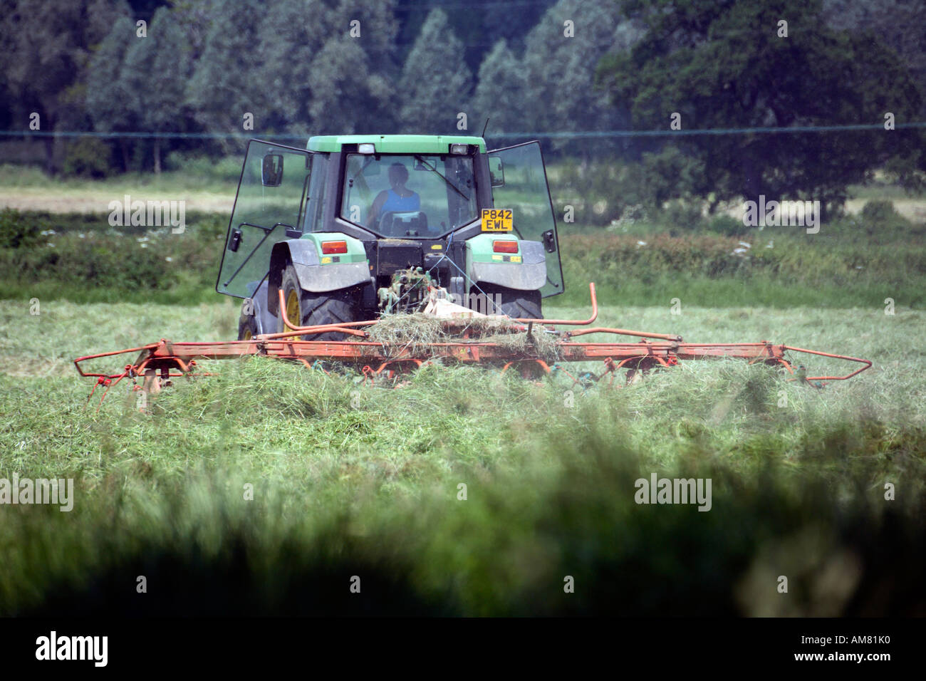 Female farm worker in tractor turning hay in summer 6 Stock Photo - Alamy