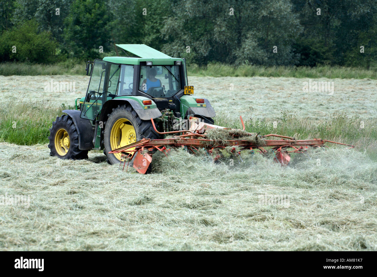 Female farm worker in tractor turning hay in summer 8 Stock Photo - Alamy