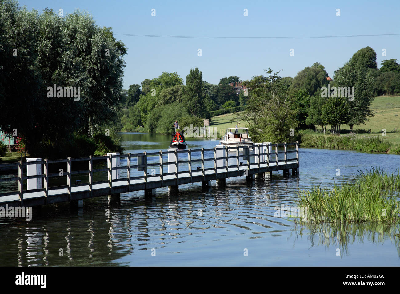 Barge and pleasure boat approaching lock at Shiplake on river Thames ...