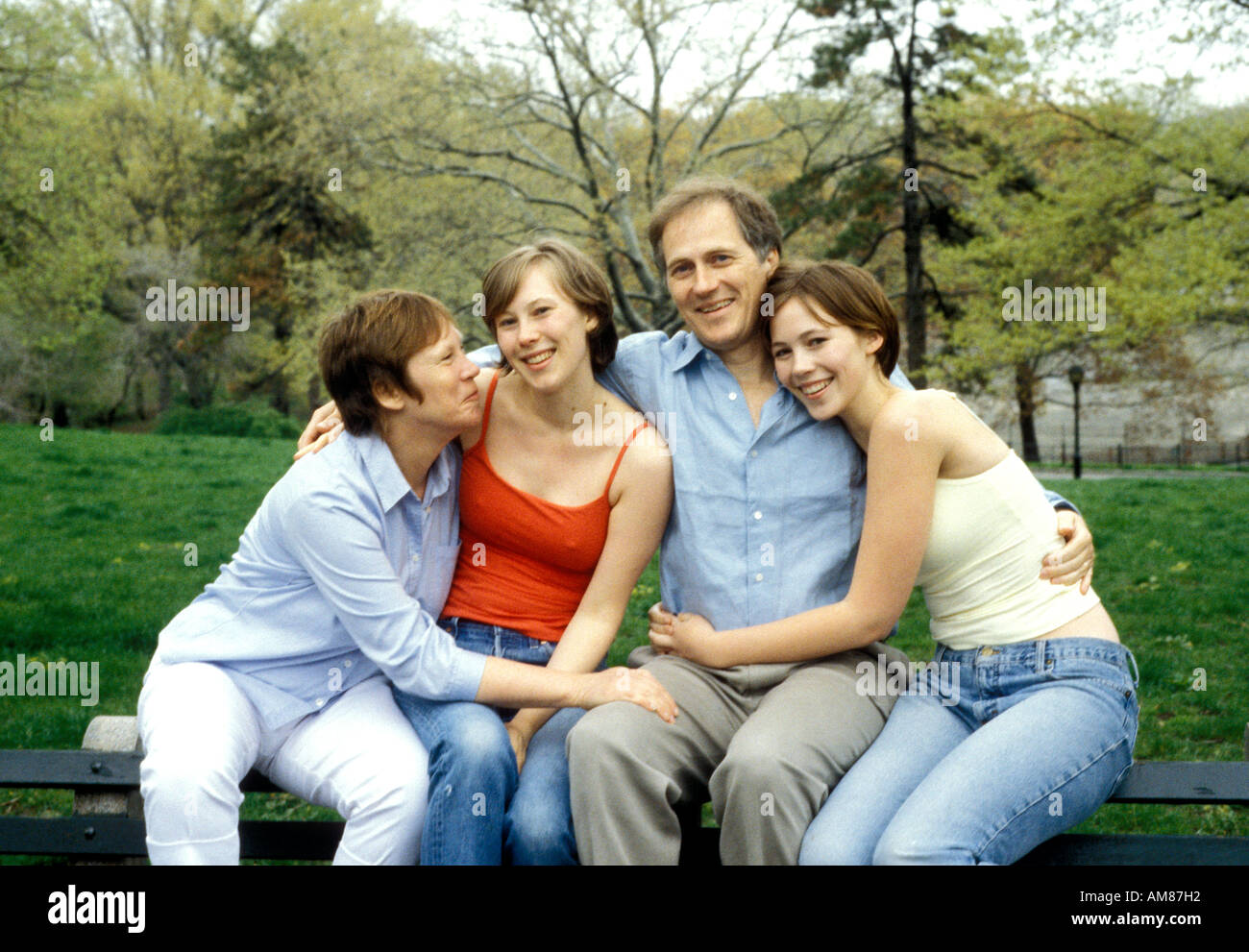 Family sitting on bench, hugging, portrait Stock Photo - Alamy