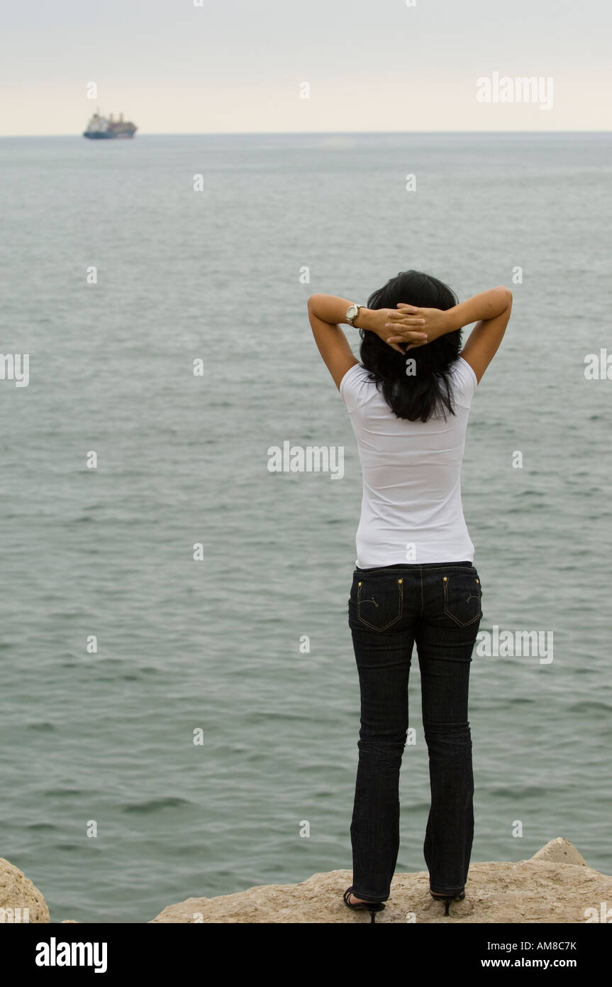 Woman watching ship leaving Stock Photo - Alamy
