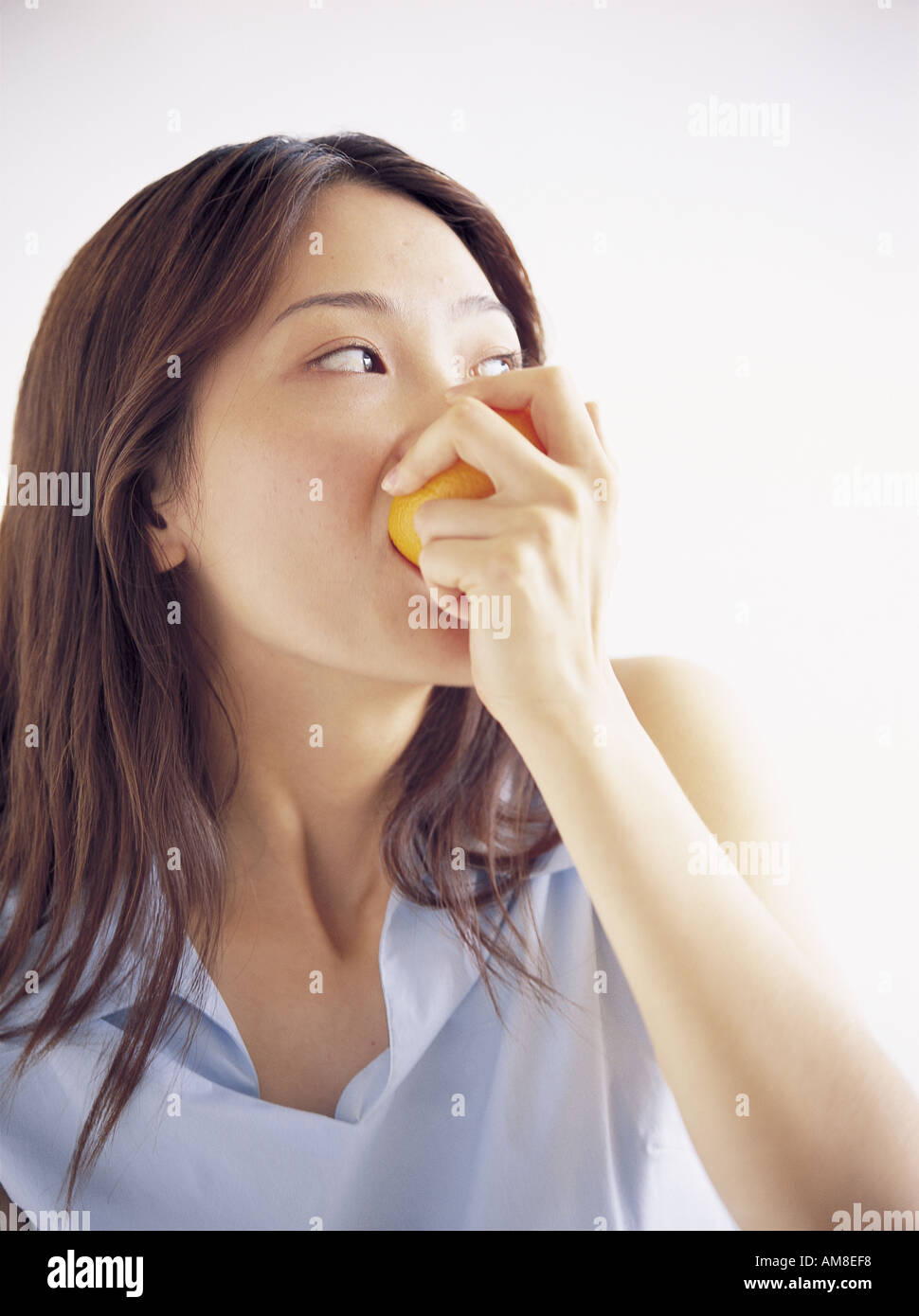 Woman eating orange Stock Photo - Alamy
