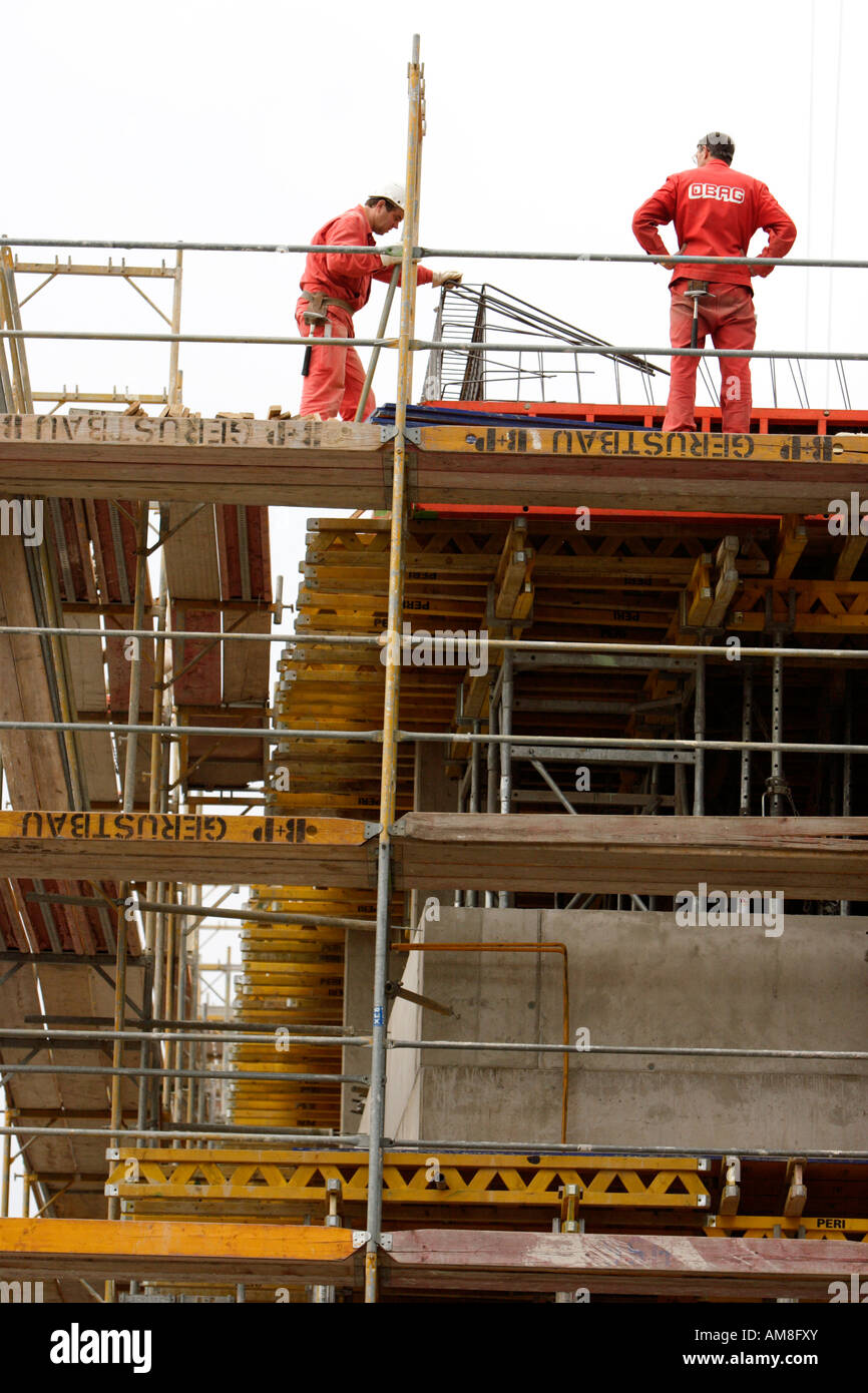 Two worker work at a construction site for a new office building in ...