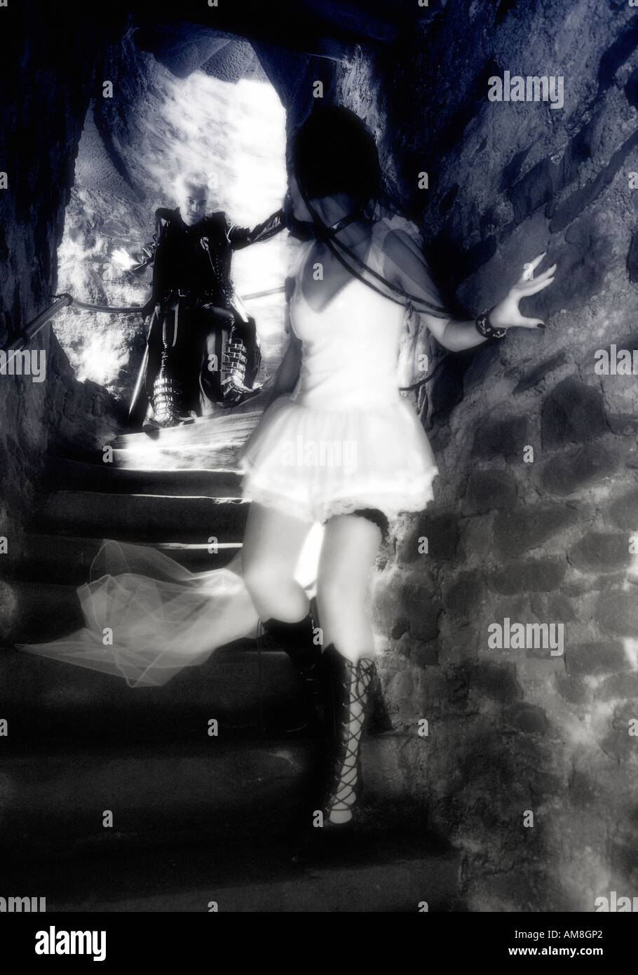 A male dressed in black chasing a single female dressed in white down a ...