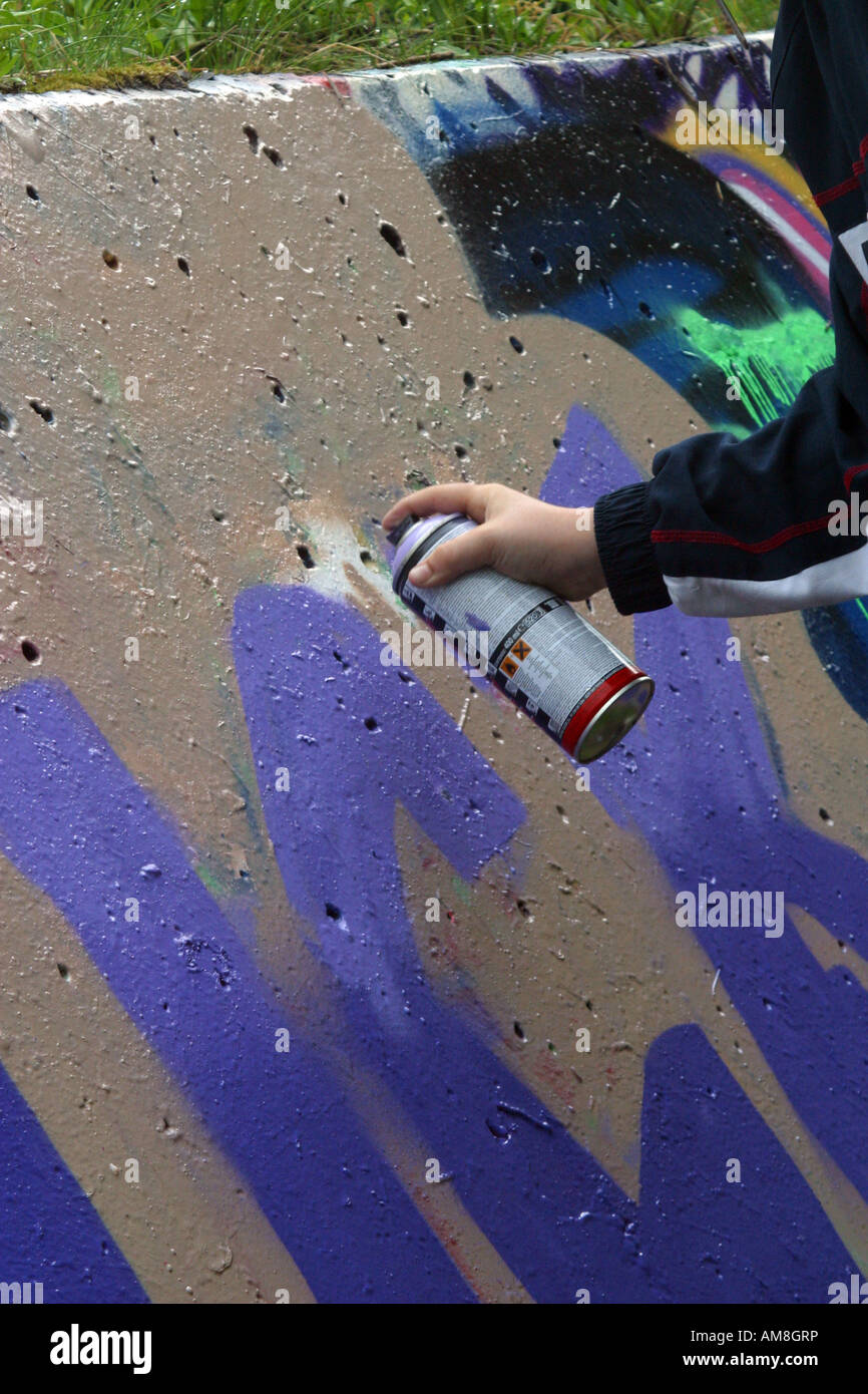 Youth spraying Graffiti on a wall Stock Photo - Alamy