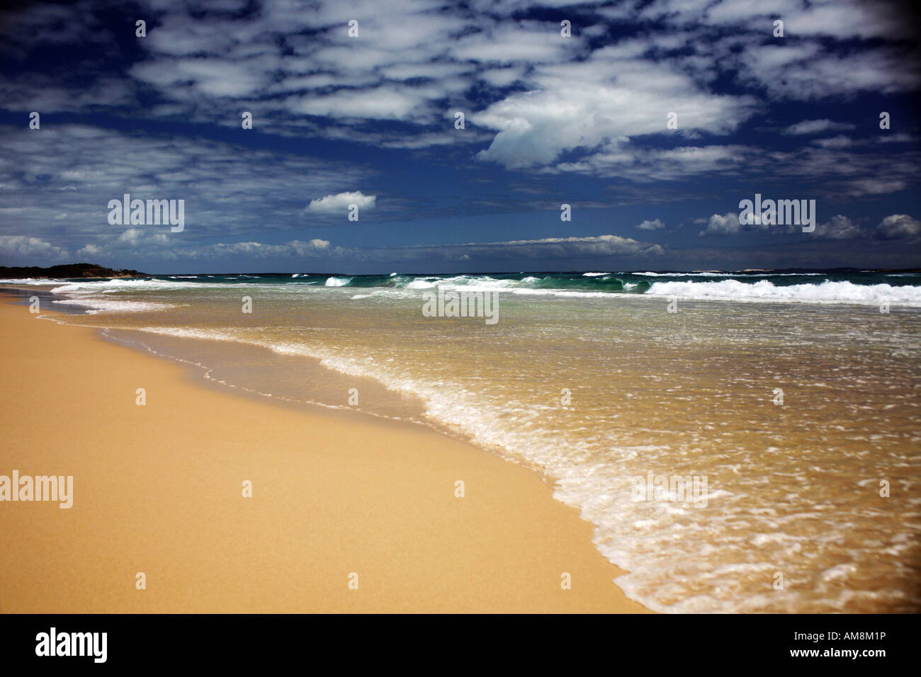 Tide coming onto a golden sandy beach Australia Stock Photo - Alamy