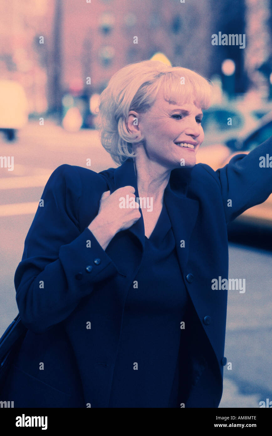 Mature woman waving out in road Stock Photo - Alamy