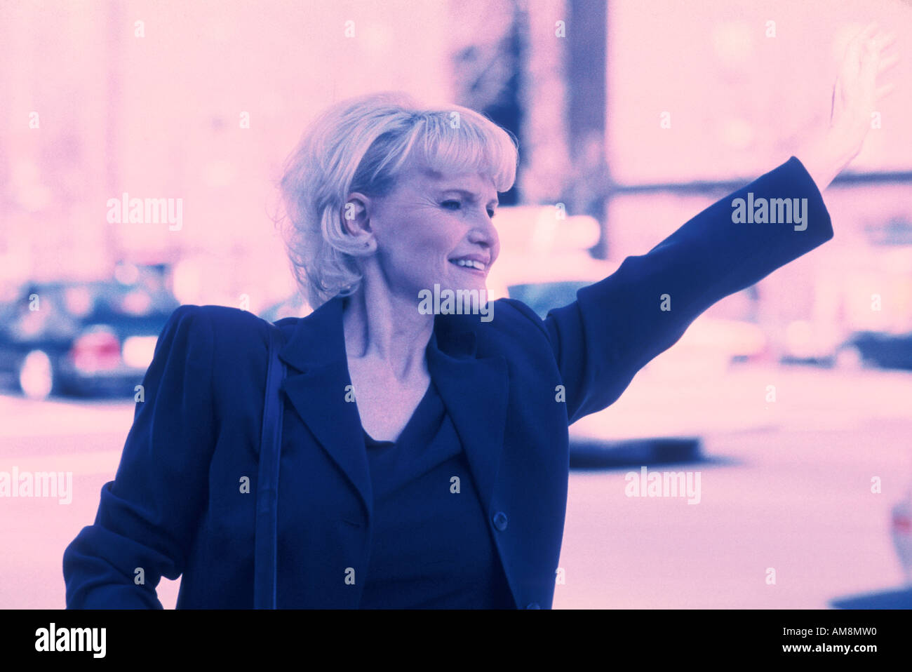 Mature woman waving out in road Stock Photo - Alamy