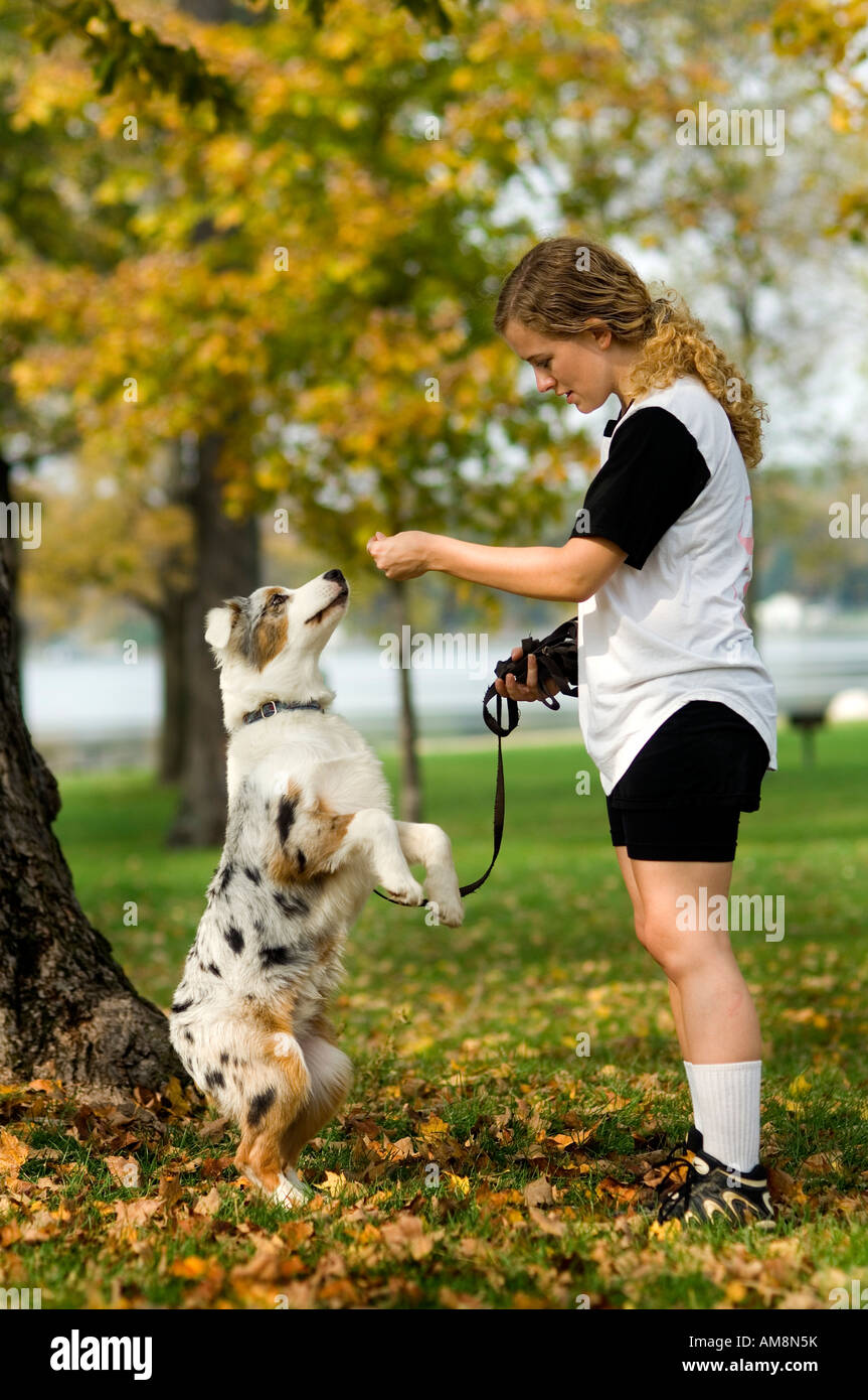 A girl in her softball uniform playing with her dog Stock Photo - Alamy