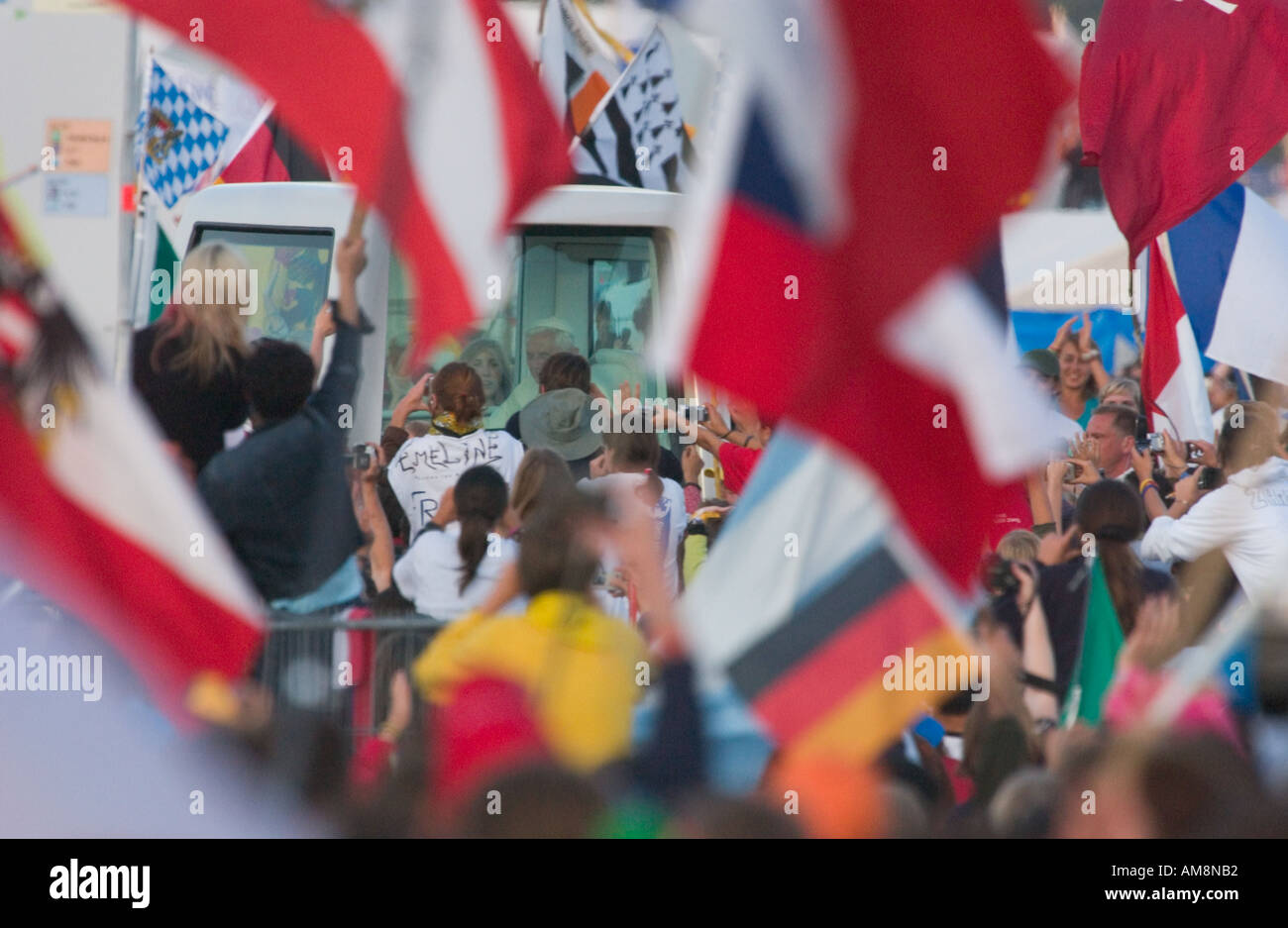Pope Benedictus XVI in the Popemobile amidst a crowd of flag waving ...