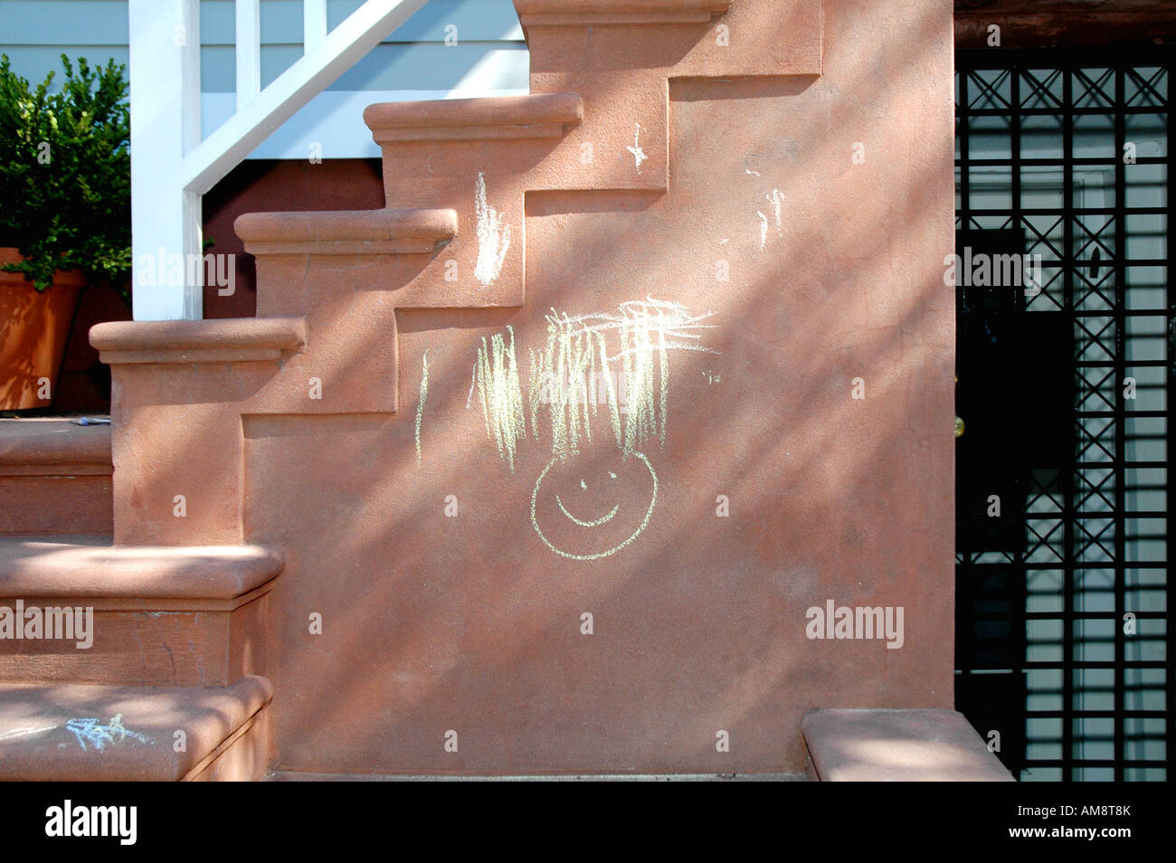young childs chalk drawing of a smiley face on residential cement ...