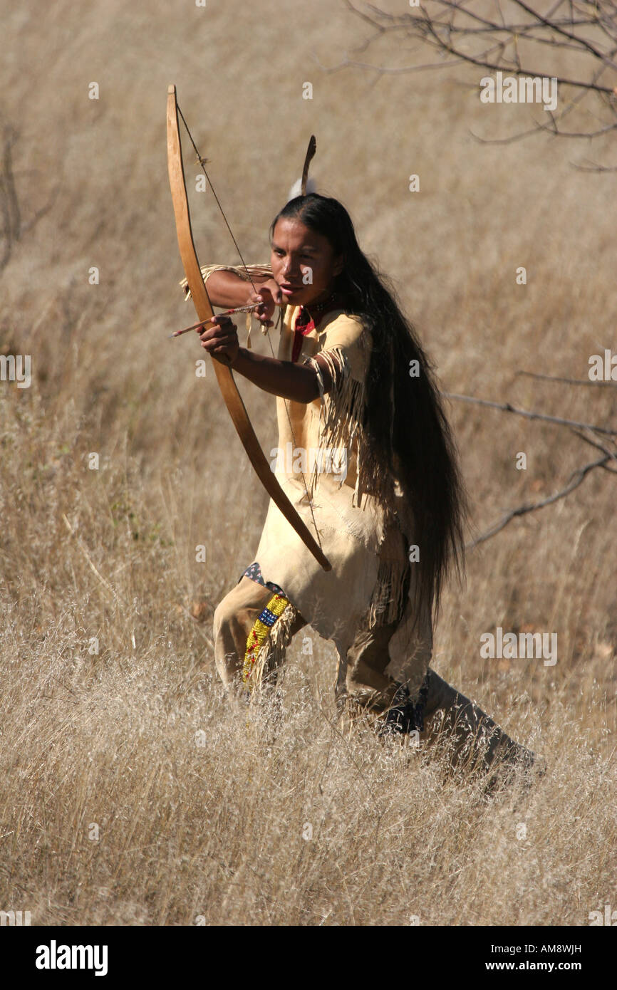 A young Native American Indian boy using or hunting with a bow and ...