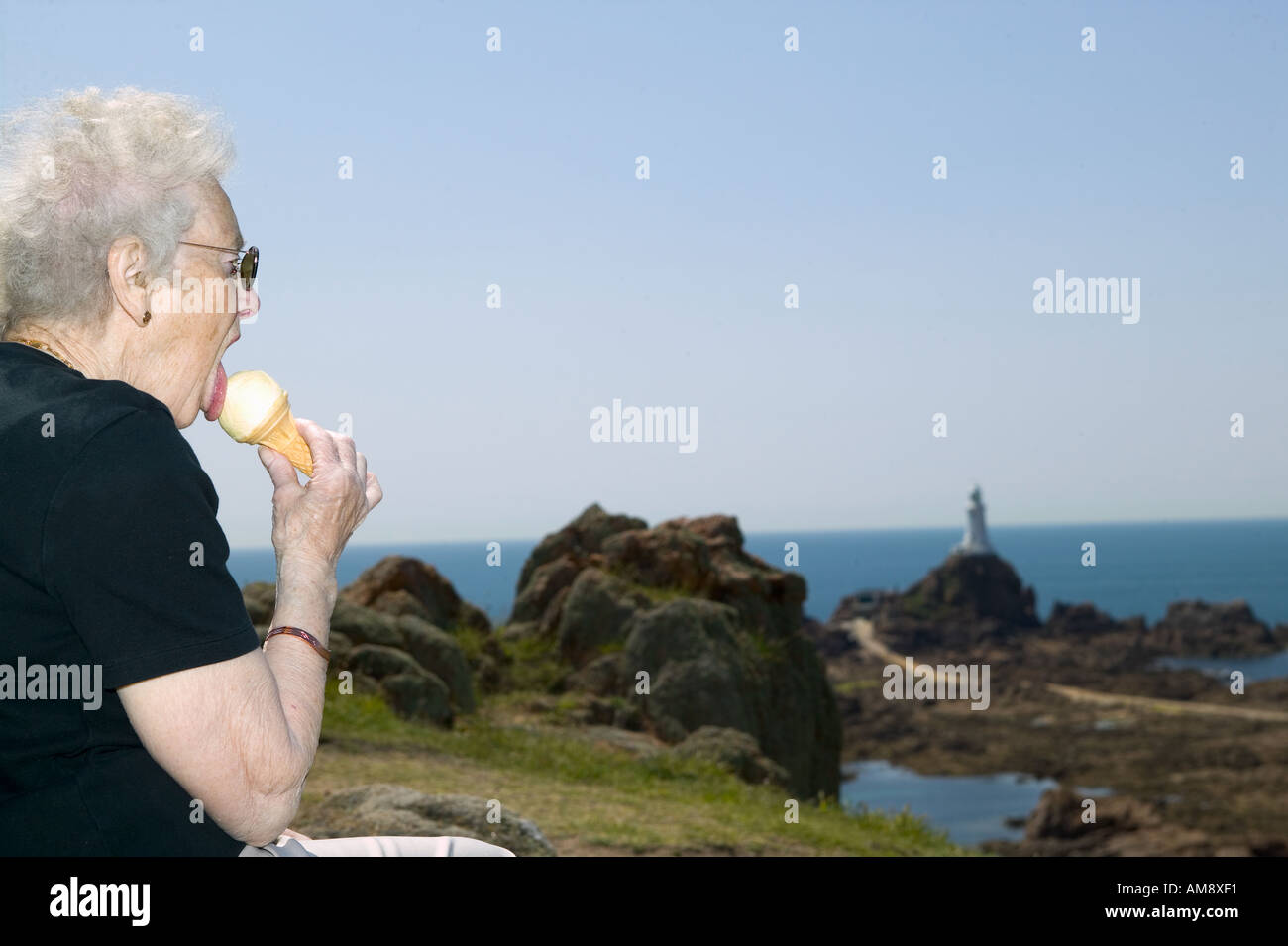 Elderly lady with white white hair eating ice cream in front of ...