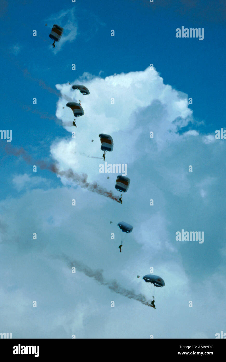 Parachute team descending and trailing smoke Stock Photo - Alamy