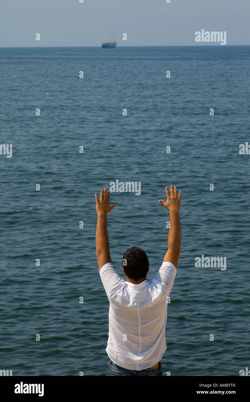 Man calling for the ship by the sea Stock Photo - Alamy