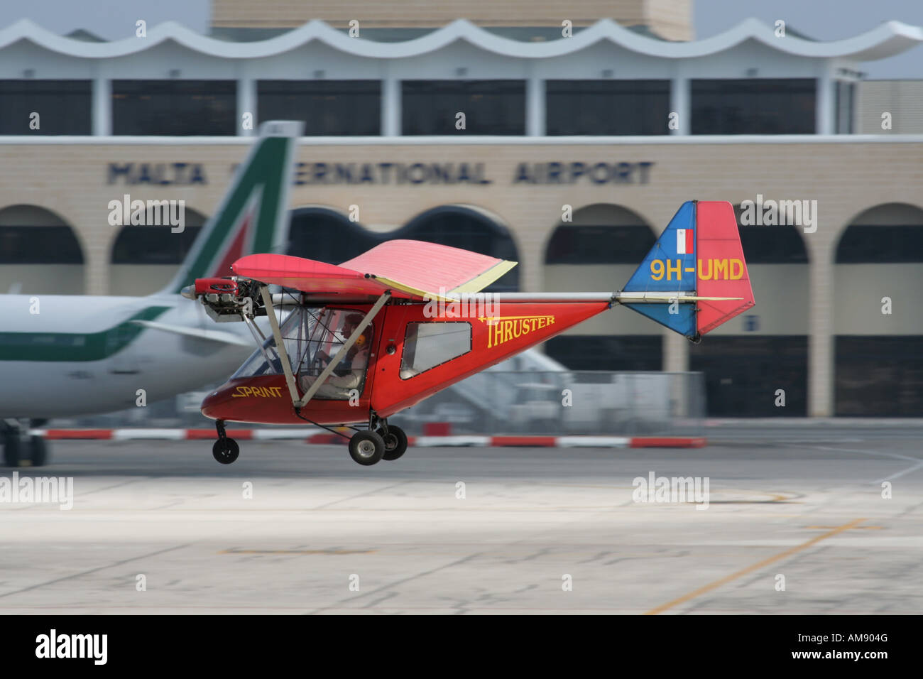 Thruster T-600N microlight aircraft flying at low level over the runway ...