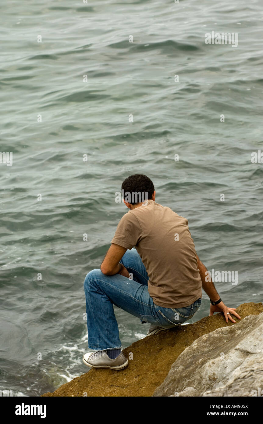 Man sitting on the edge Stock Photo - Alamy