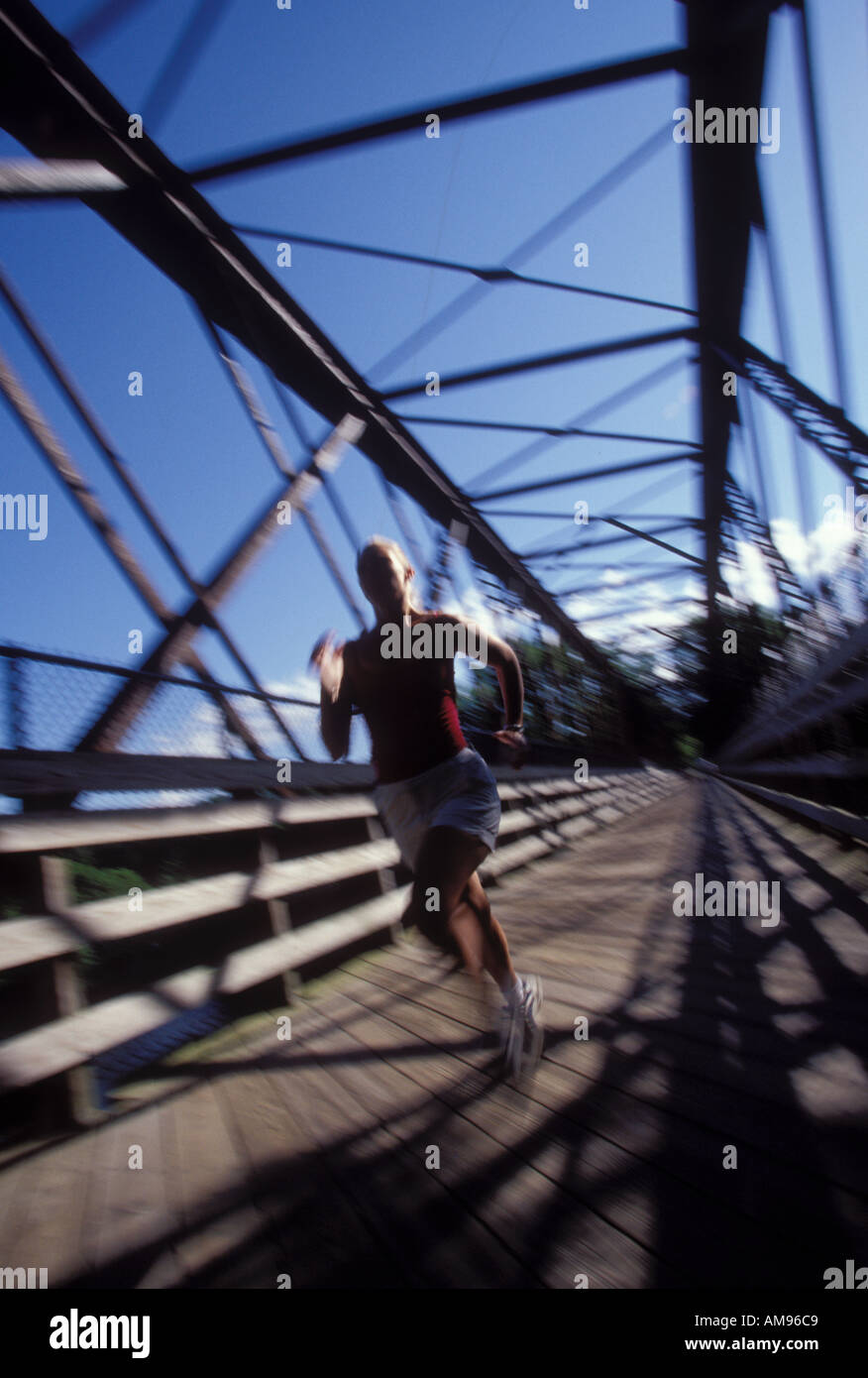 Woman running on bridge Stock Photo - Alamy