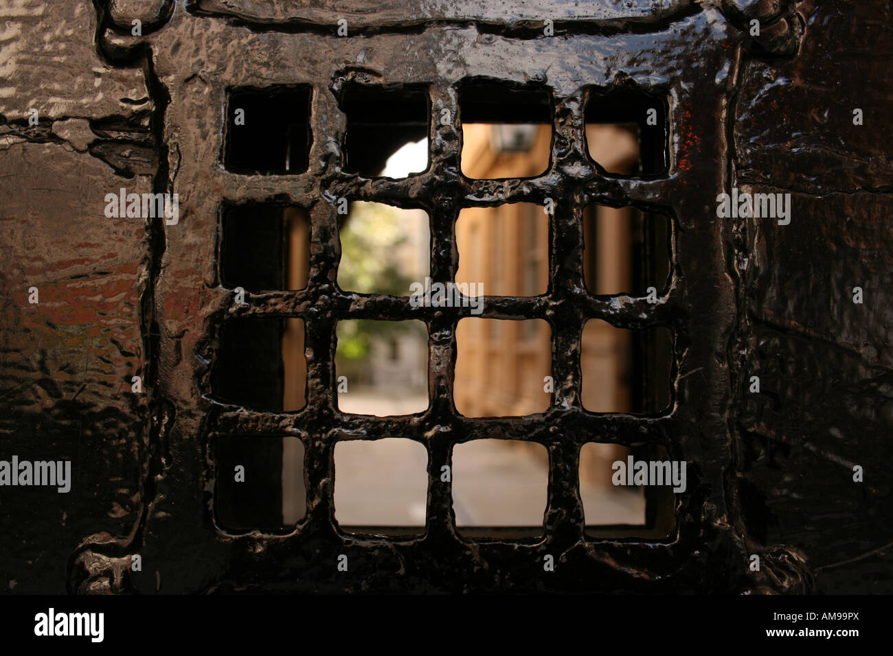 Looking through hole in gate with courtyard blurred, London England UK ...
