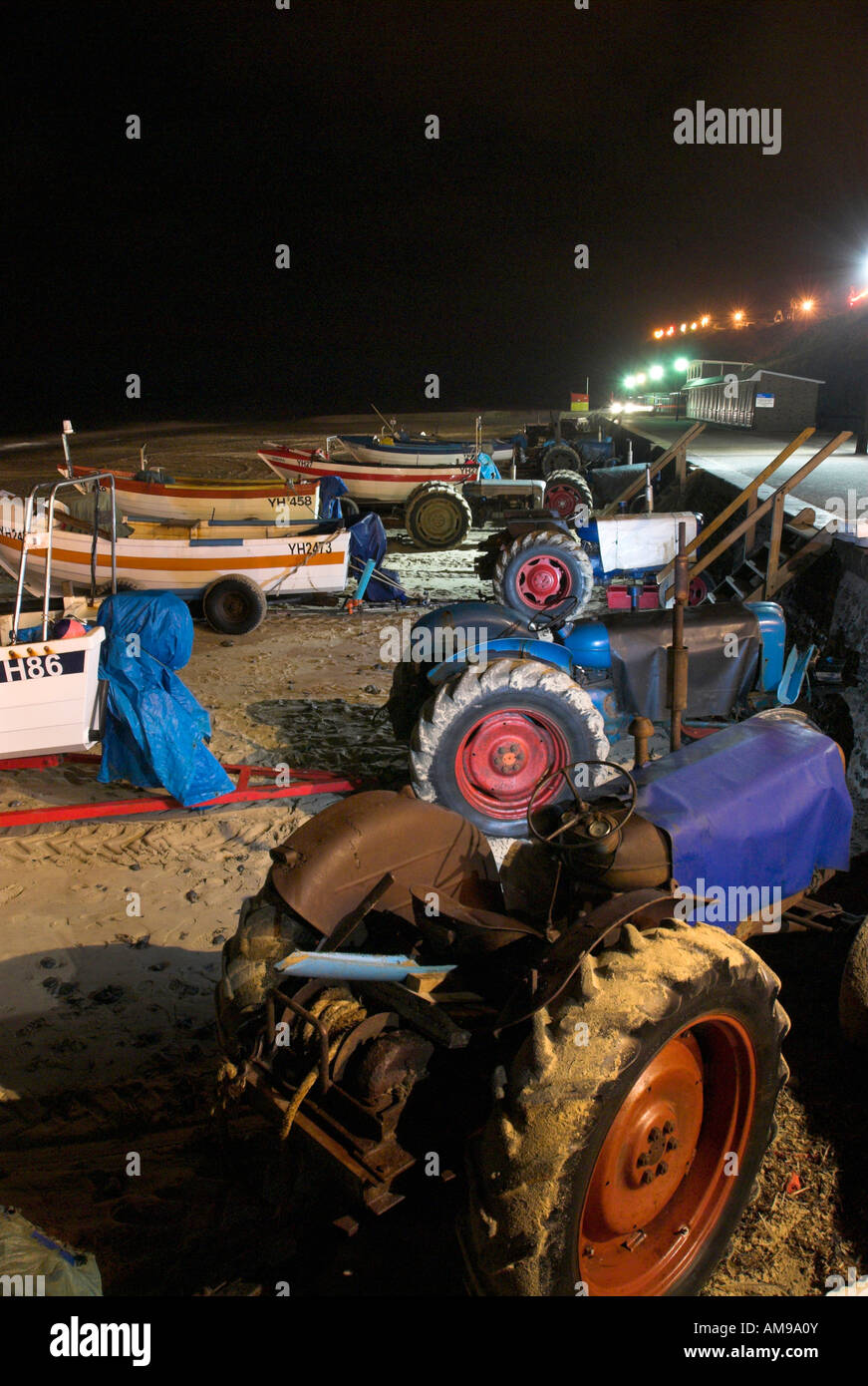 Crab fishing boats and tractors on the beach during the night in Cromer ...