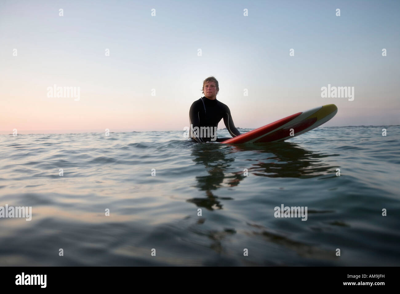 Man sitting on surfboard in hi-res stock photography and images - Alamy