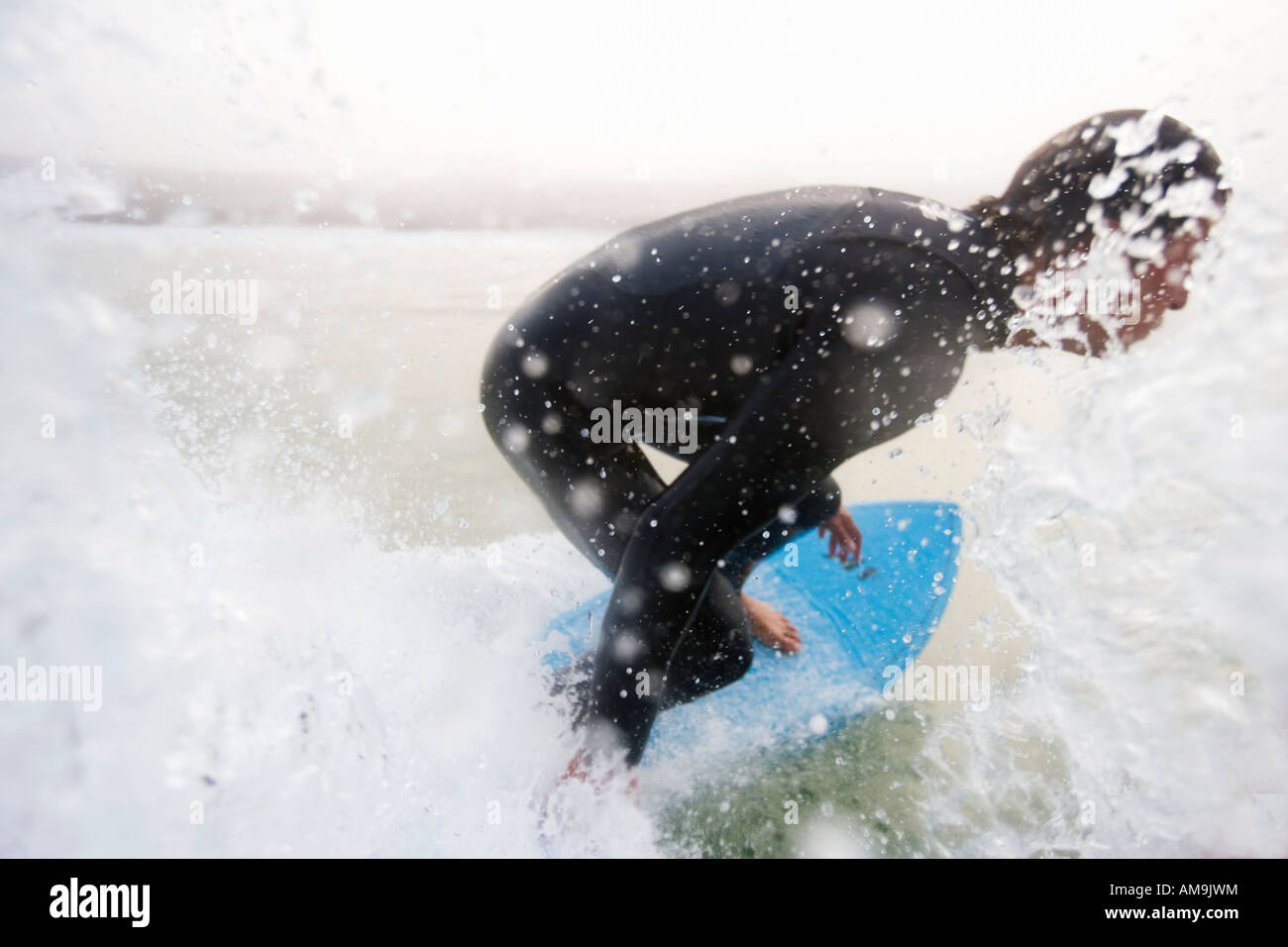 Man on surfboard splashing water Stock Photo - Alamy