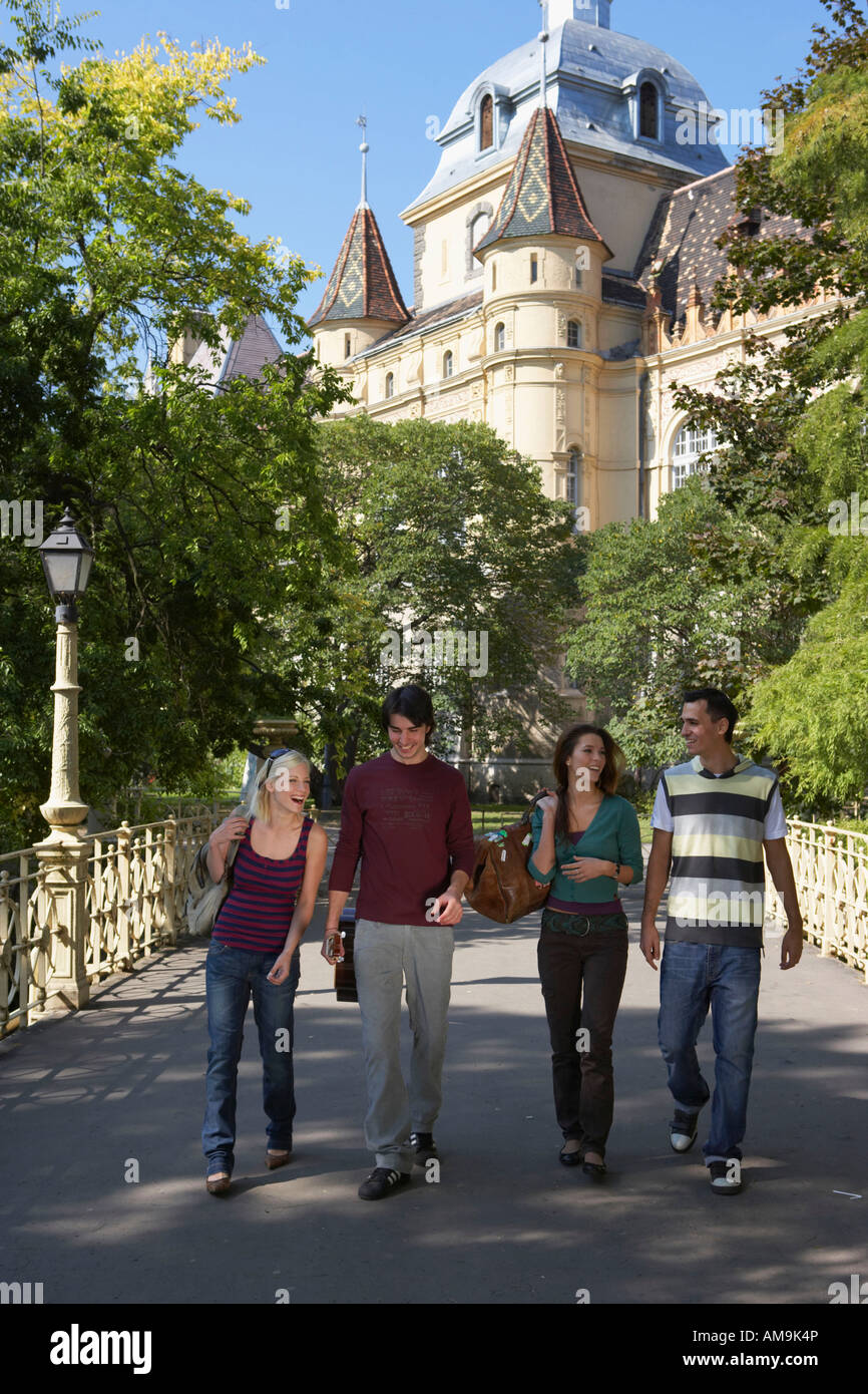 Four friends walking on a bridge smiling Stock Photo - Alamy