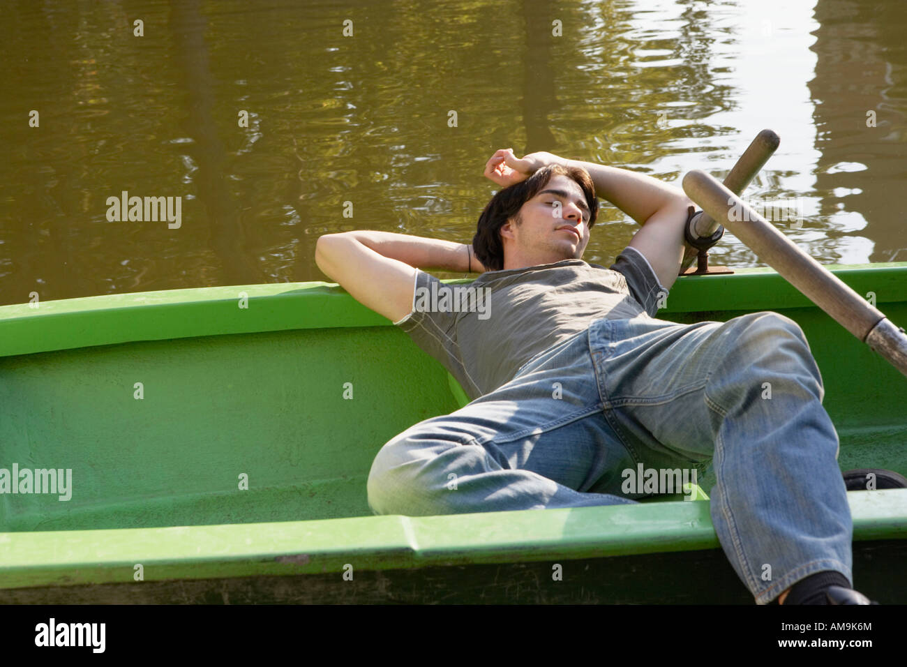 Man sleeping in a rowboat Stock Photo - Alamy